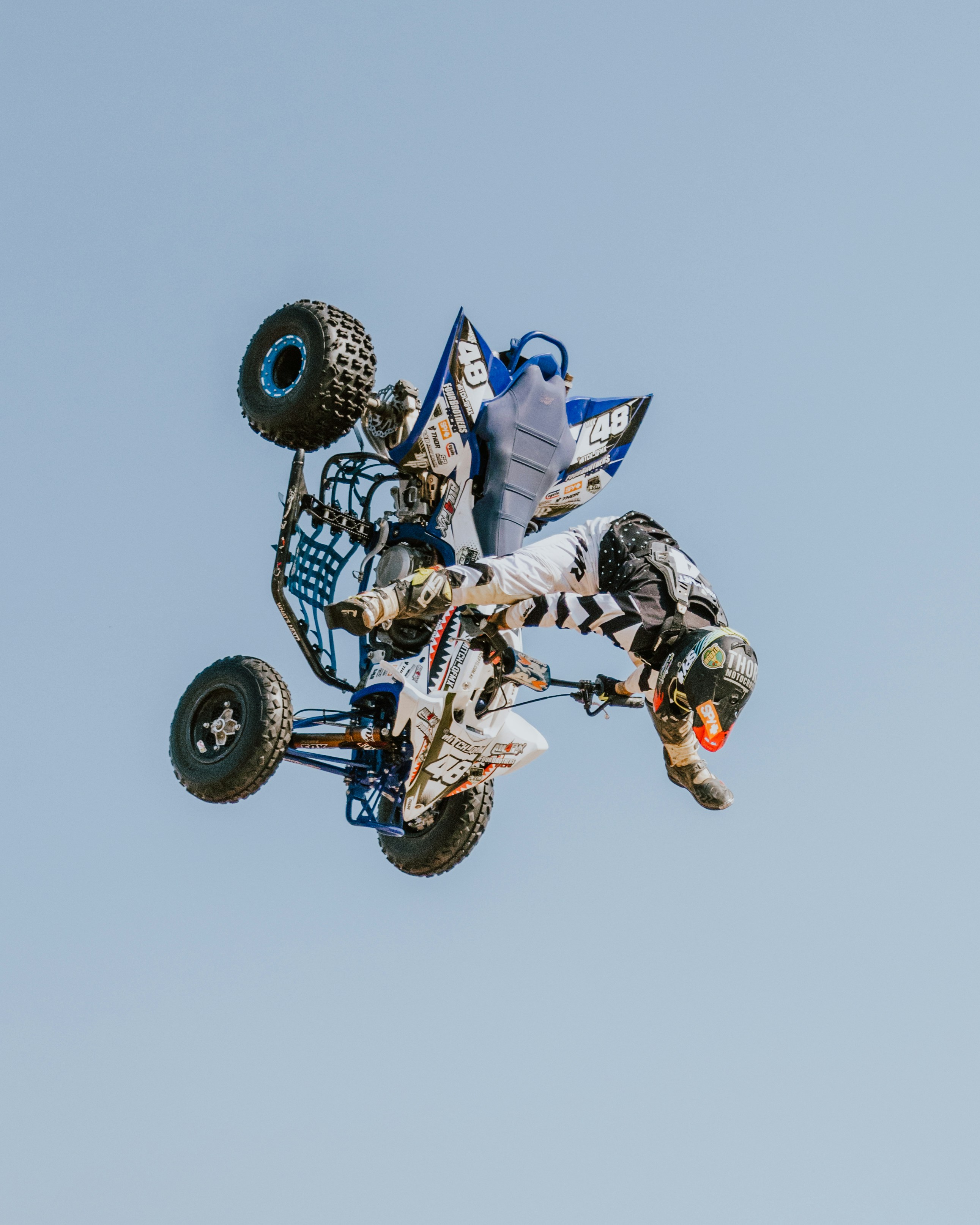 Aerial Stunt: Quad Bike Soars Against a Clear Sky