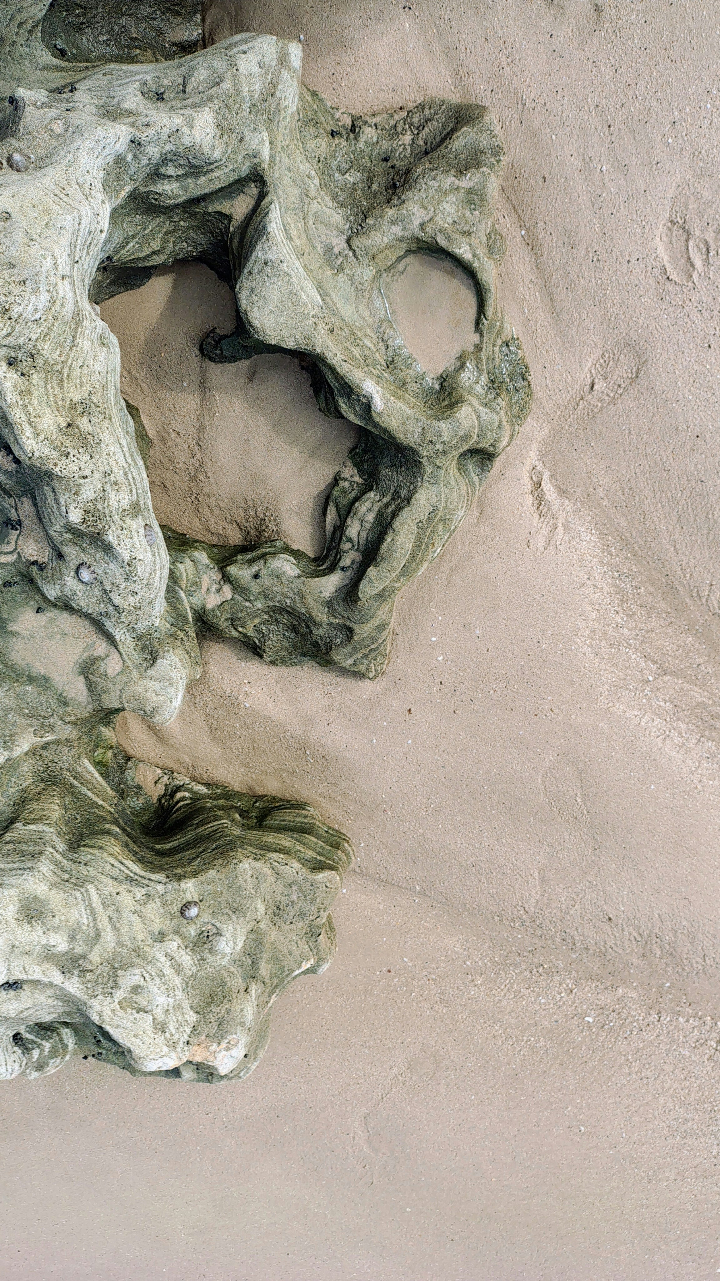 Weathered Rock Arch Framed by Shoreline Sand