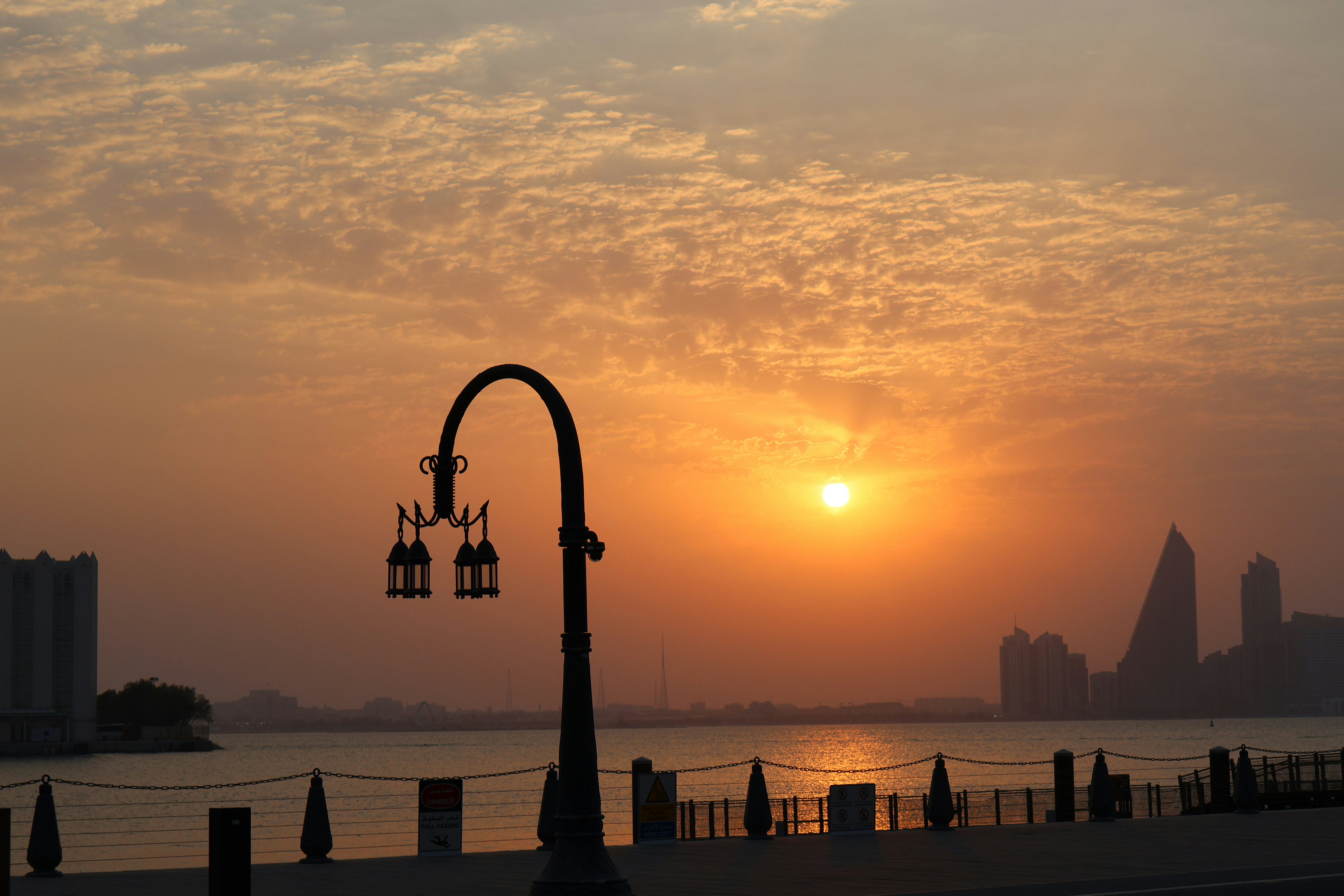 Sunset Silhouette by the Harbor Lamp