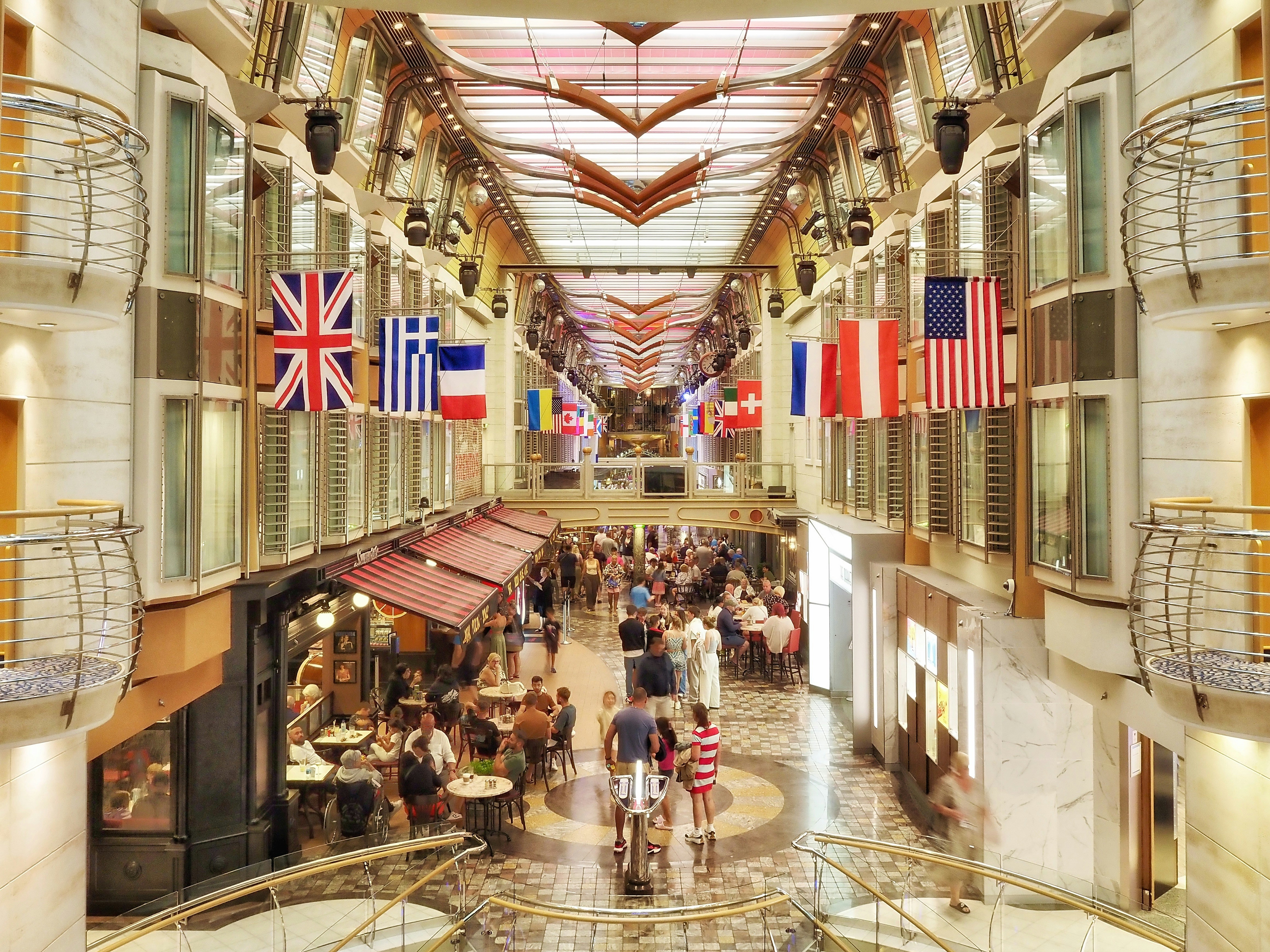 Flag-lined Atrium Venture: A Bustling Shopping Arcade Under Glass Canopy