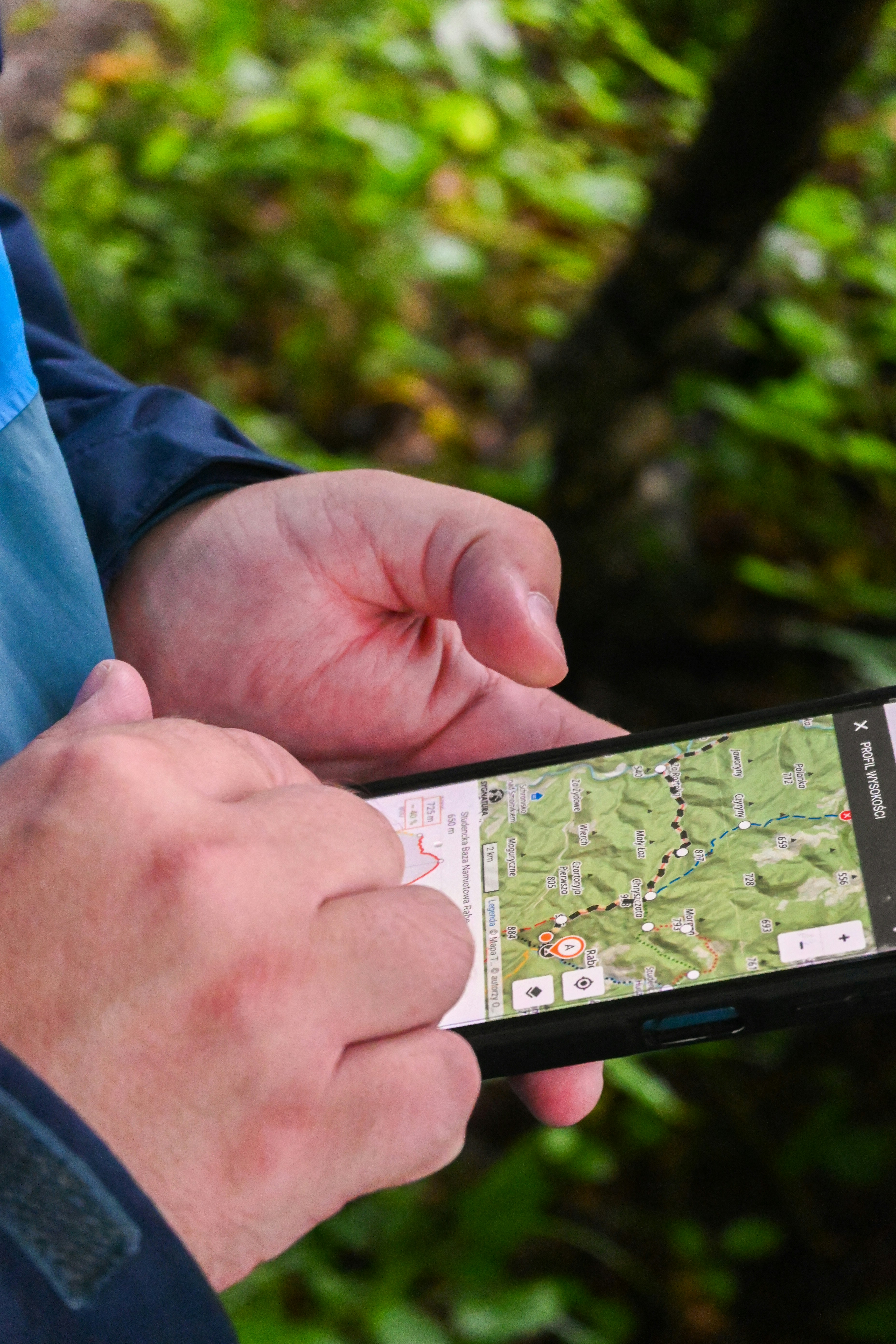 Hands in Focus: Navigating a GPS Tap with a Forest Backdrop