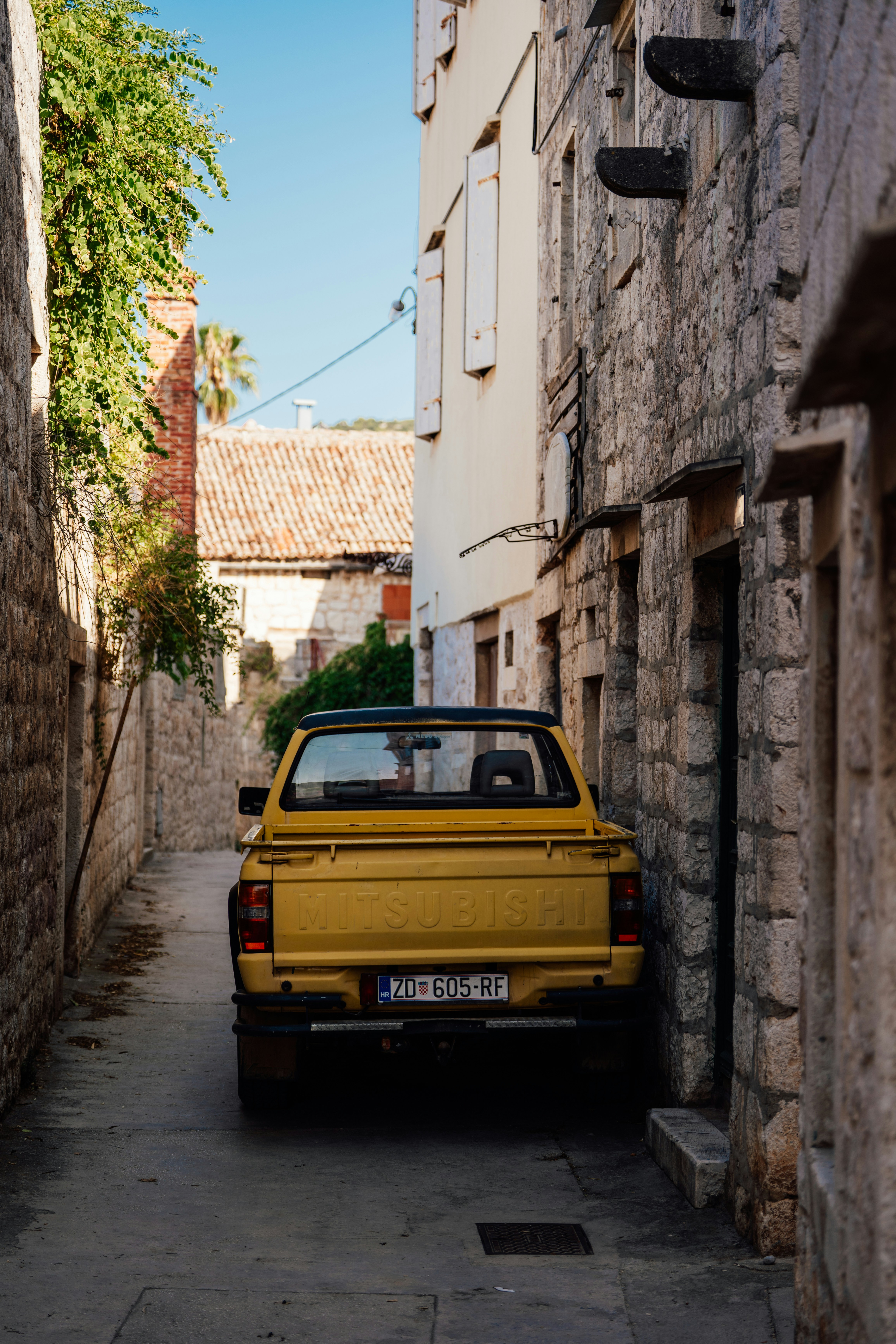 Yellow Pickup in a Sunlit Alleyway
