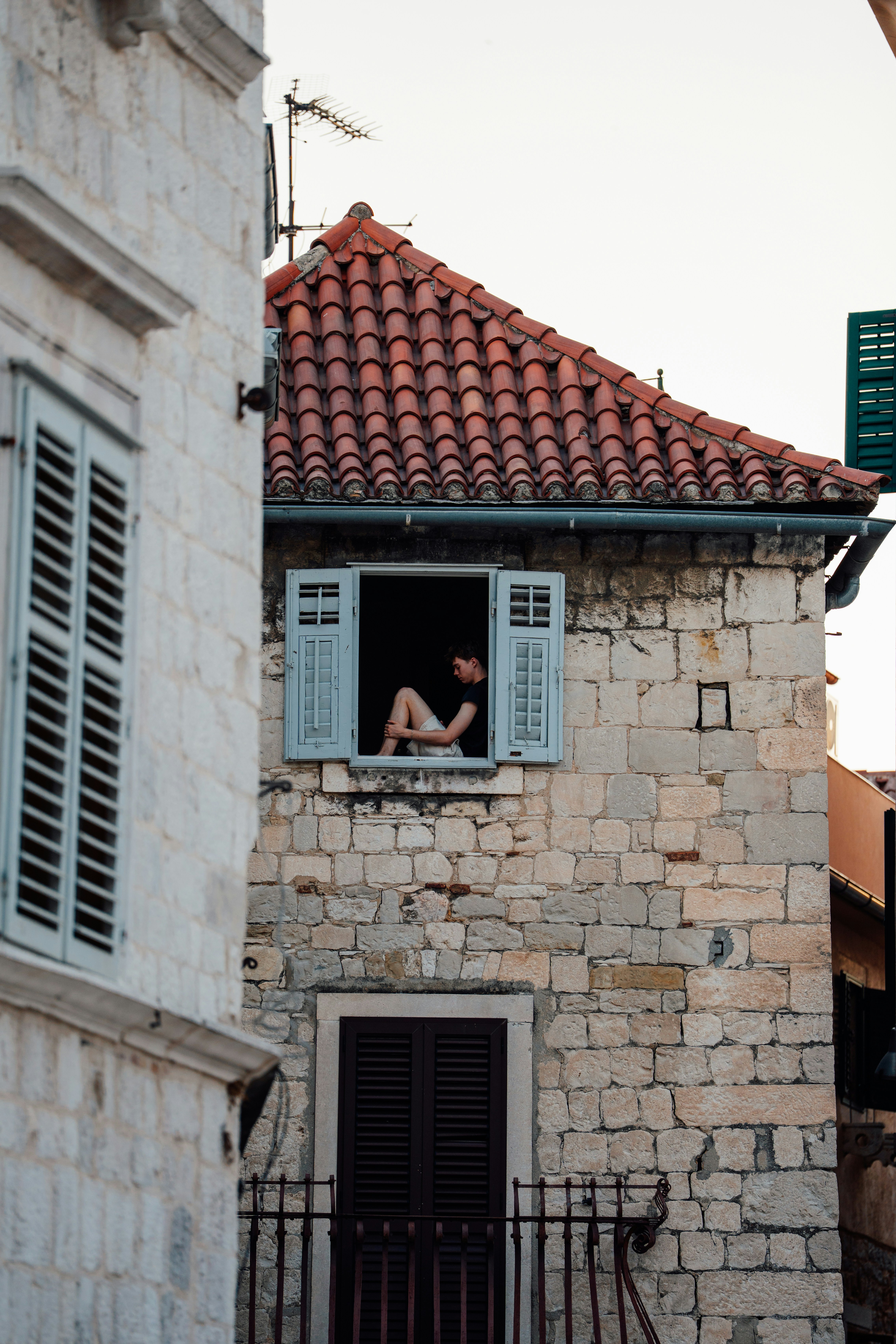 Watcher in the Windowsill: A Quiet Moment Above the Stone Wake