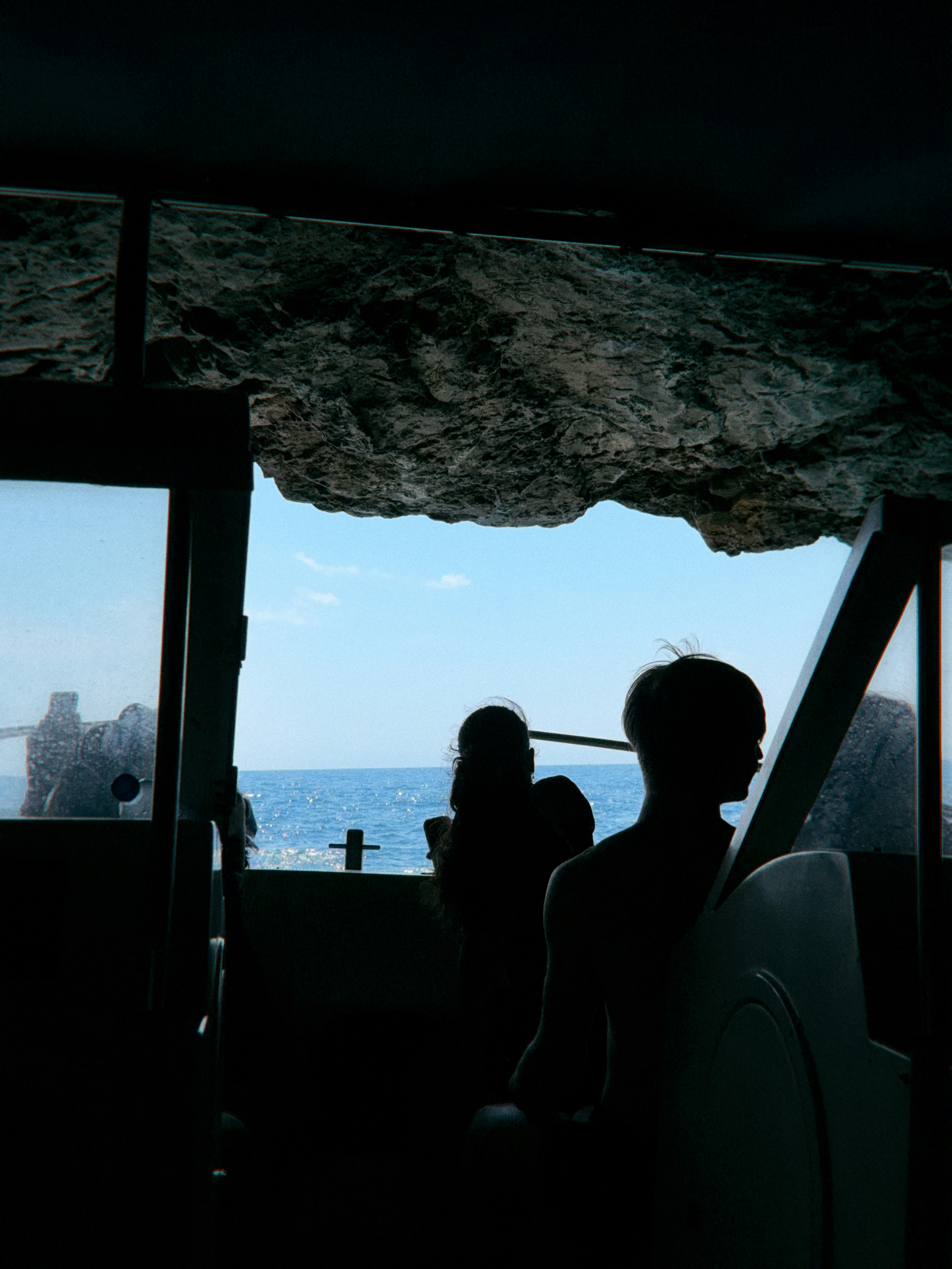 Silhouettes at Sea: A Quiet Moment on the Cave-Bed Boat