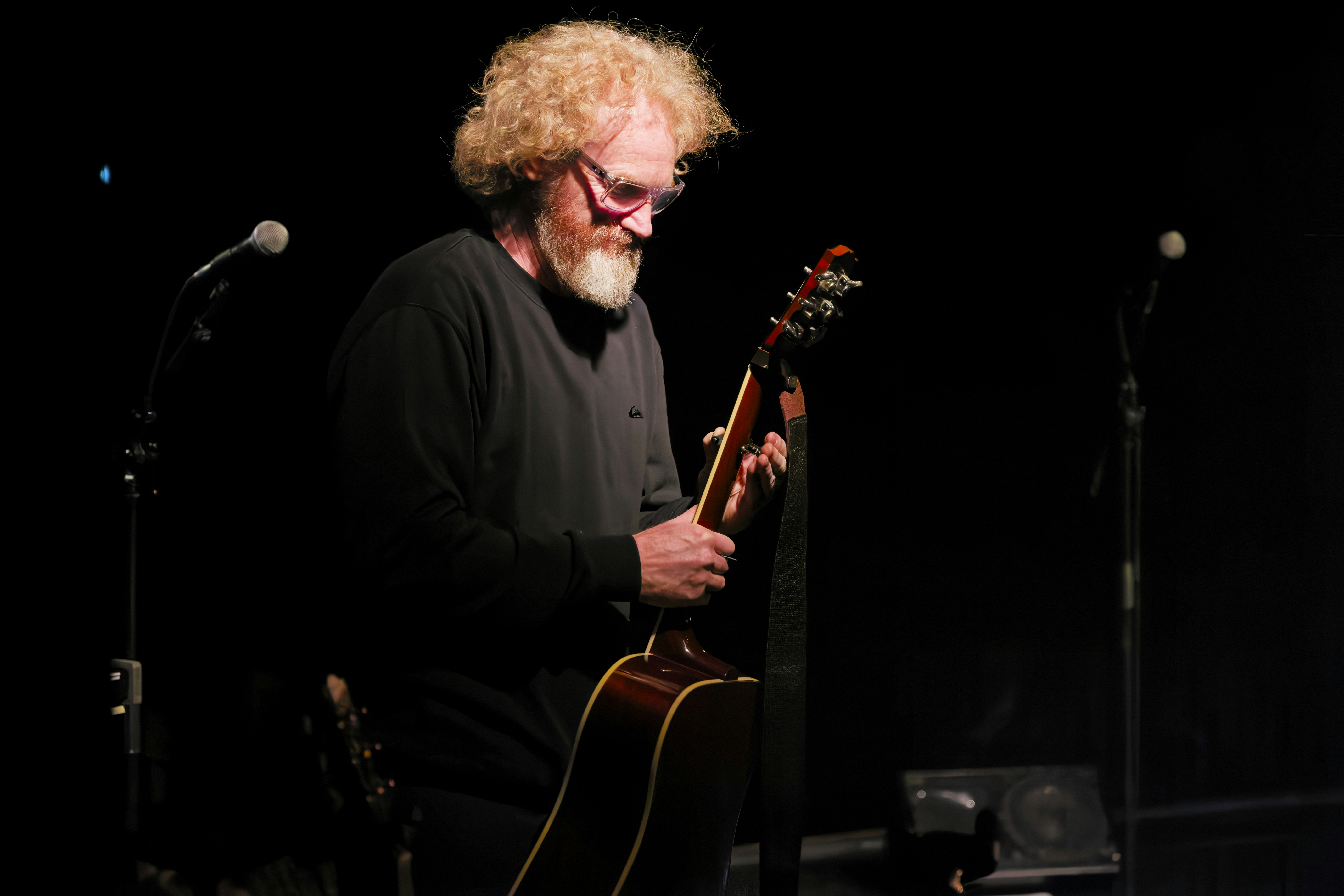 Guitarist in Spotlight: A Quiet Moment Beneath Stage Lights
