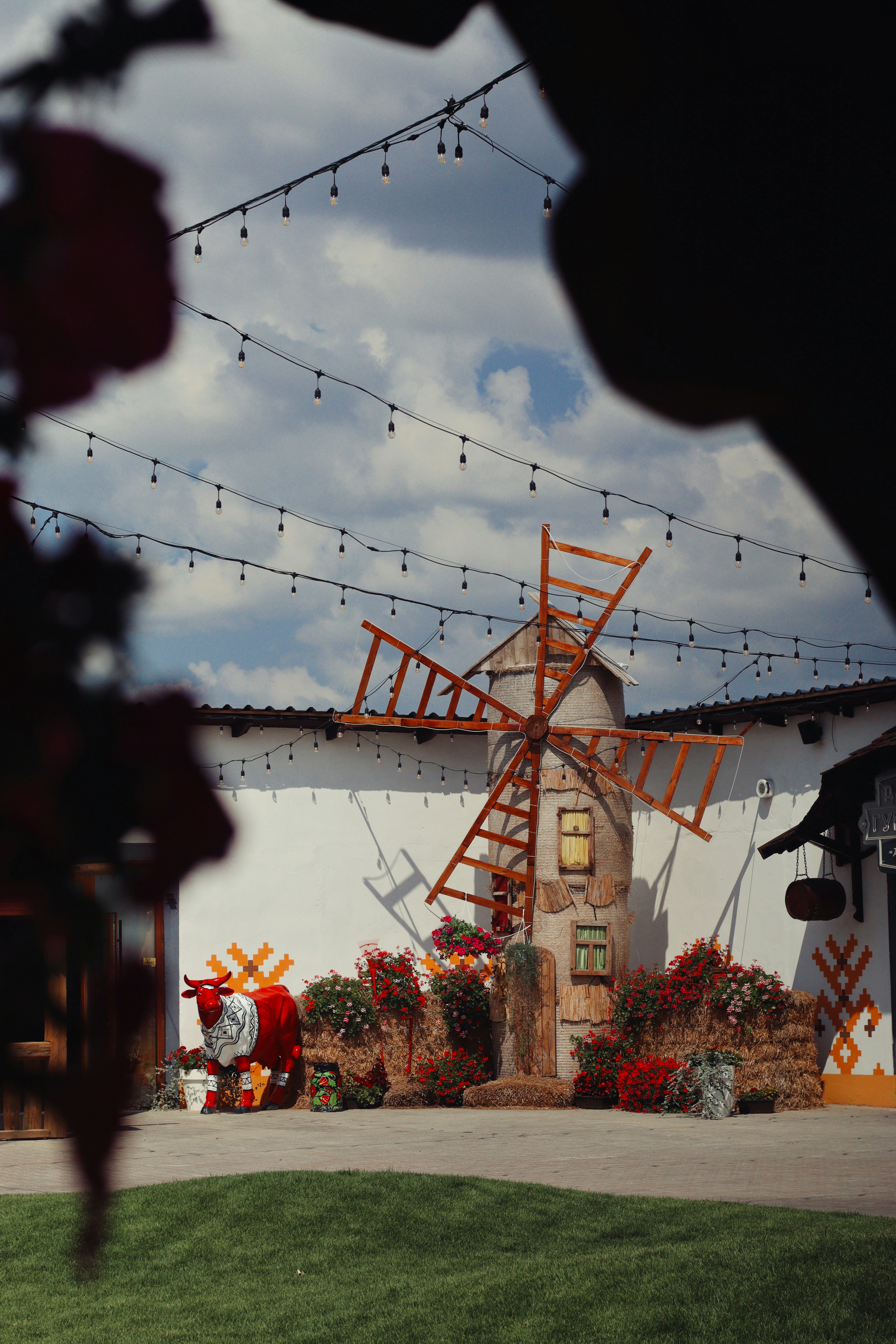 Windmill in a sunlit courtyard under string lights