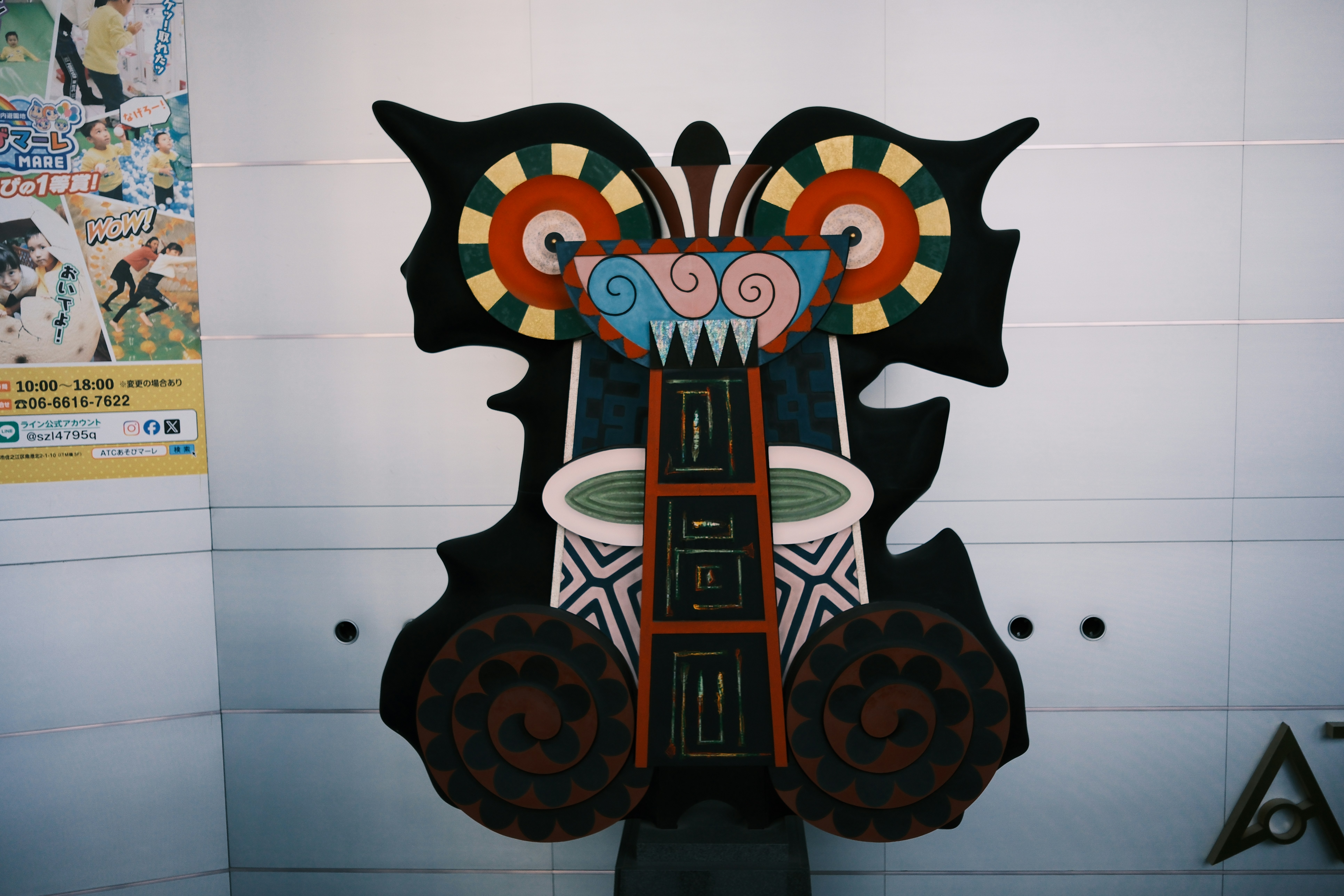 Symmetrical totem: a bold, abstract doorway guardian painted on tiled wall