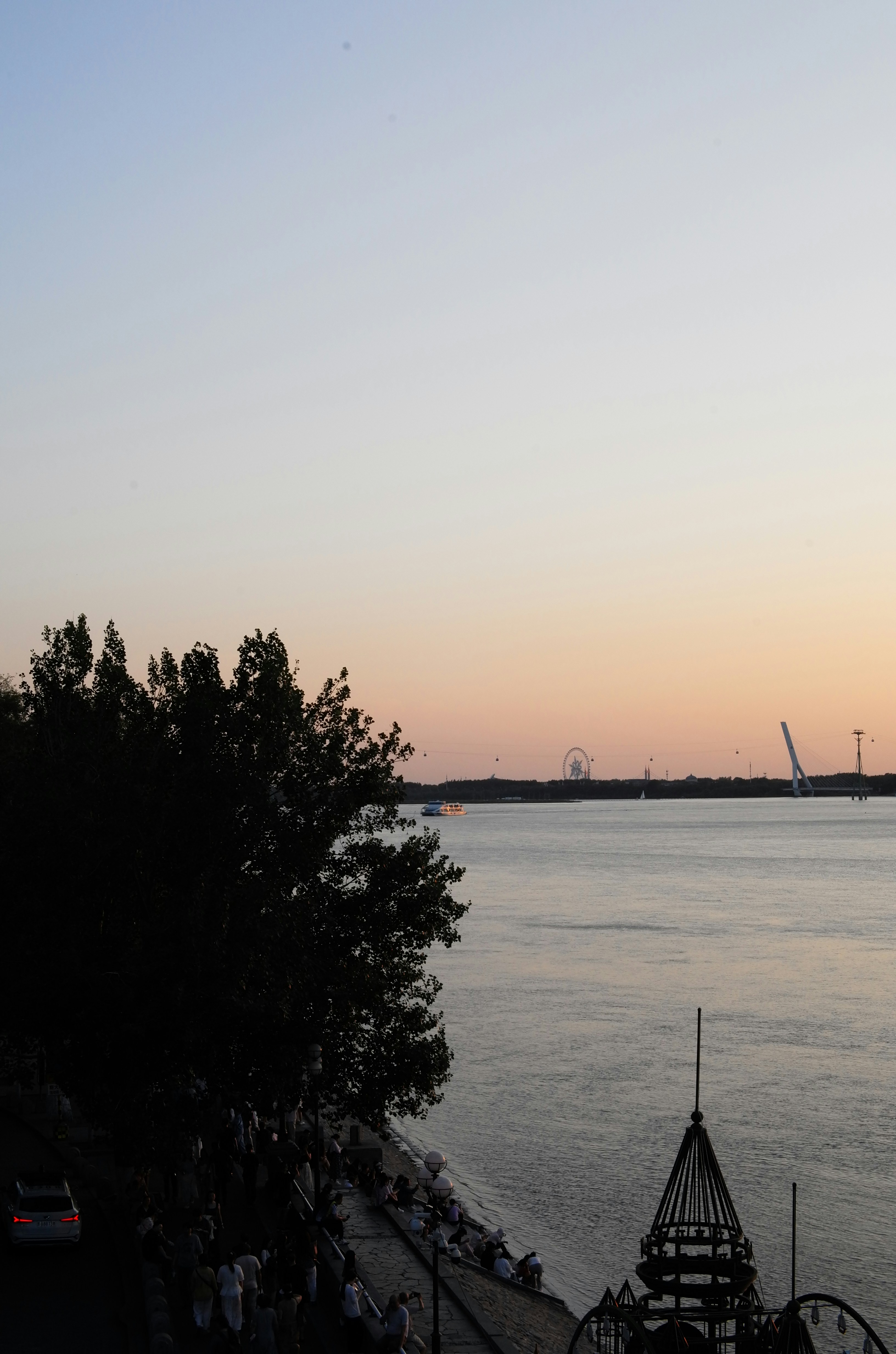 Twilight by the Riverside: People Gather Under a Pale Sky