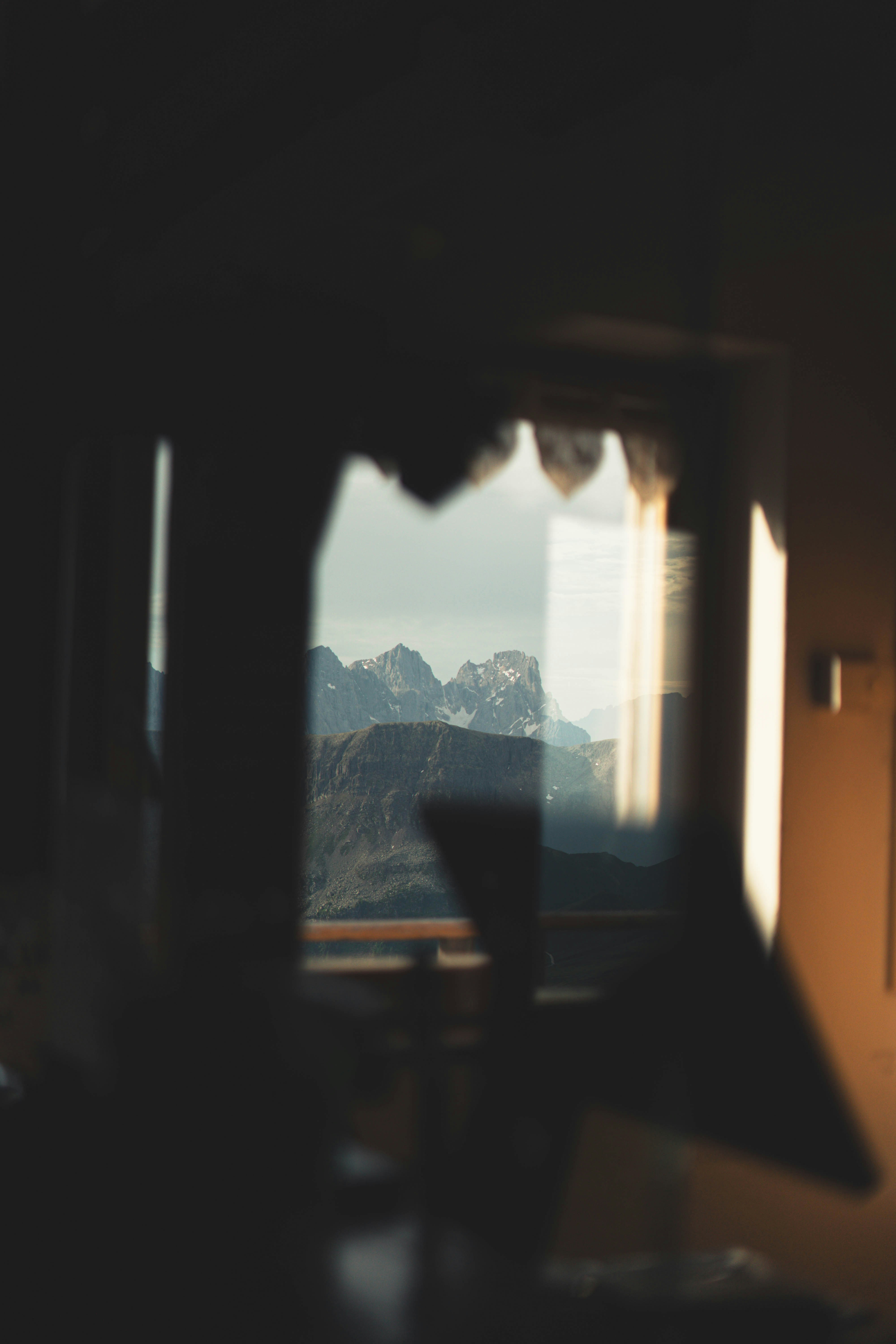 Through the Frame: Snowy Peaks framed by a dim studio window