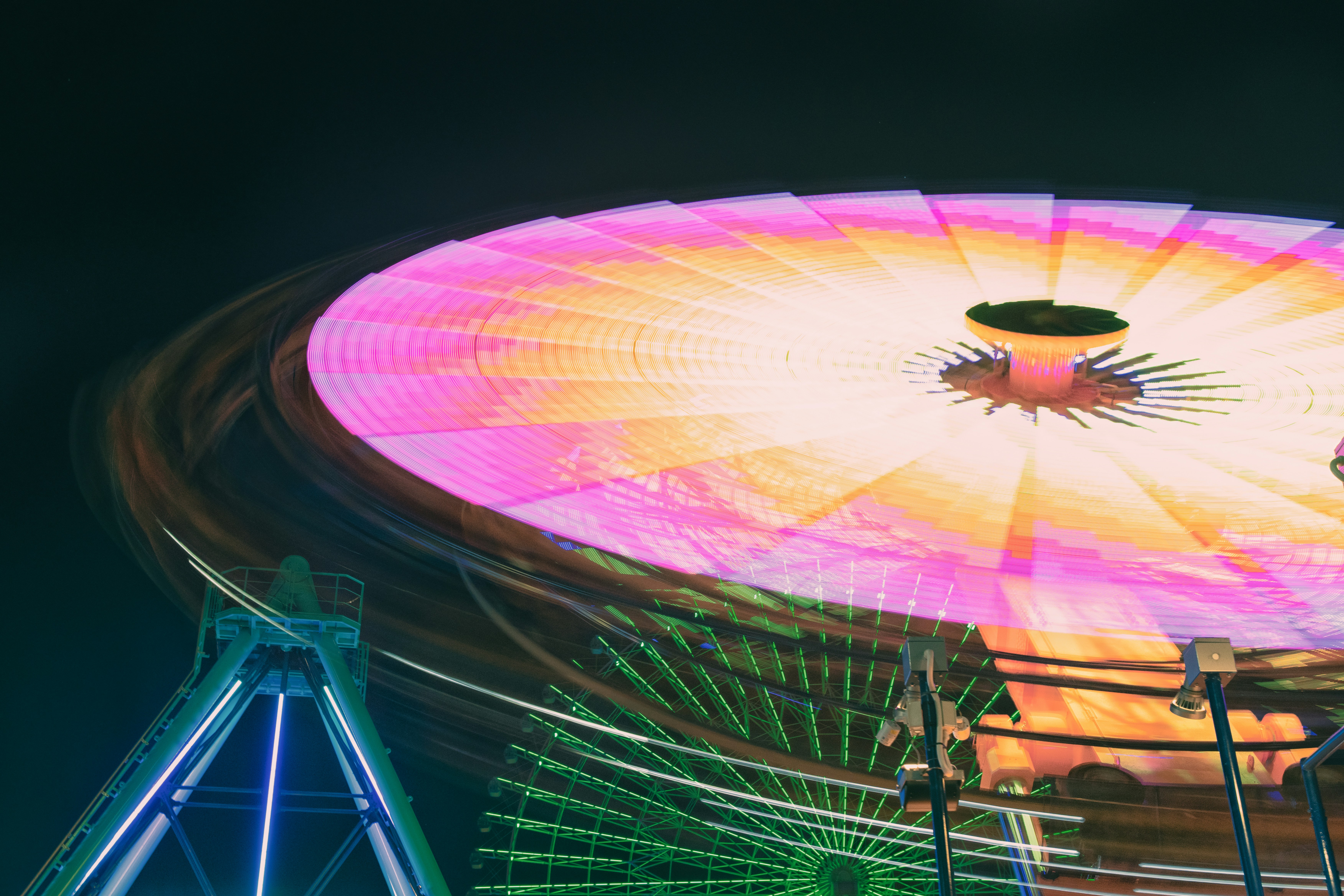 Neon Wheel of Night: A Whirl of Colorful Rides in Motion