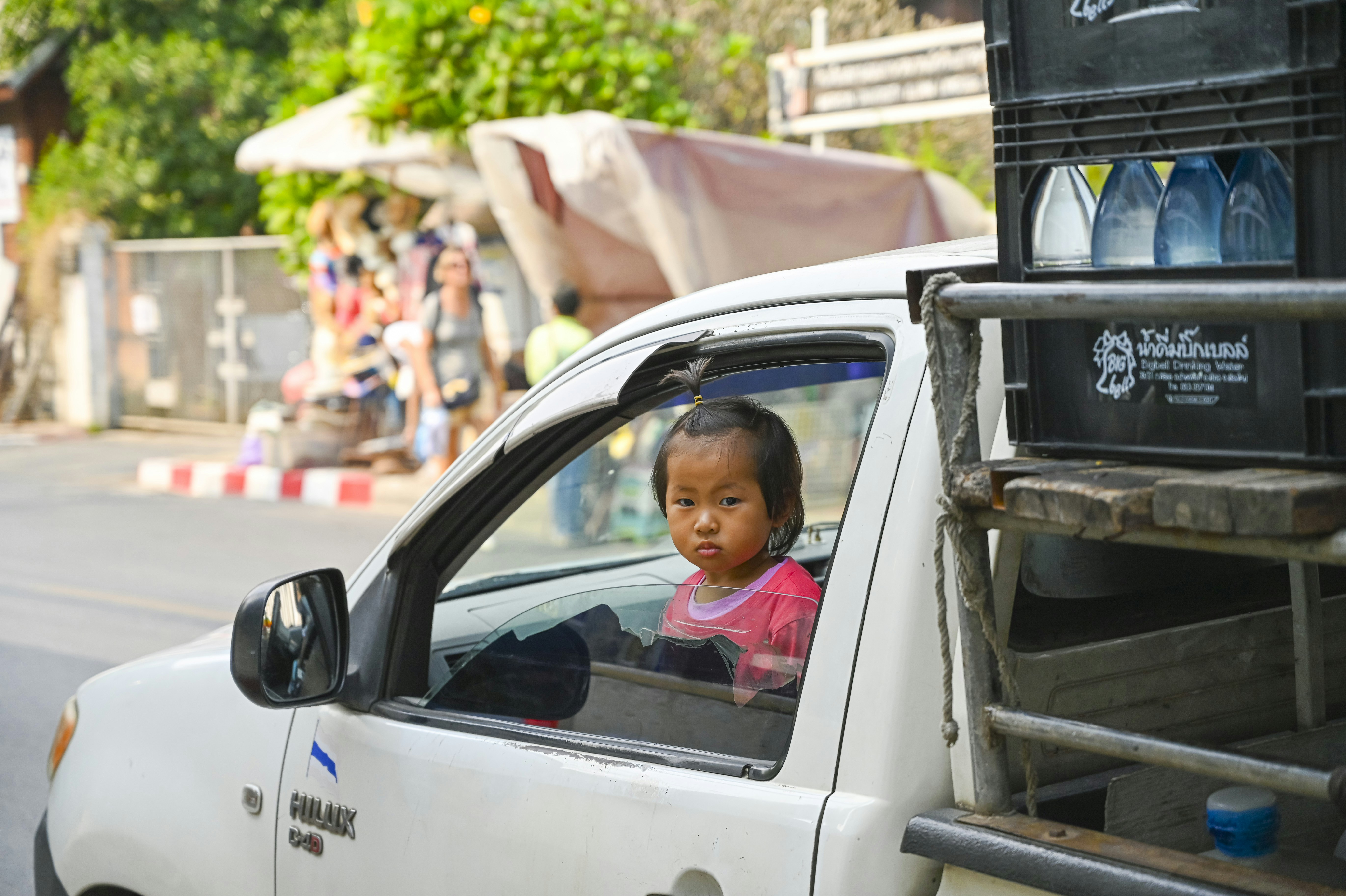 Child in a Pickup Window: A Quiet Moment on the Street