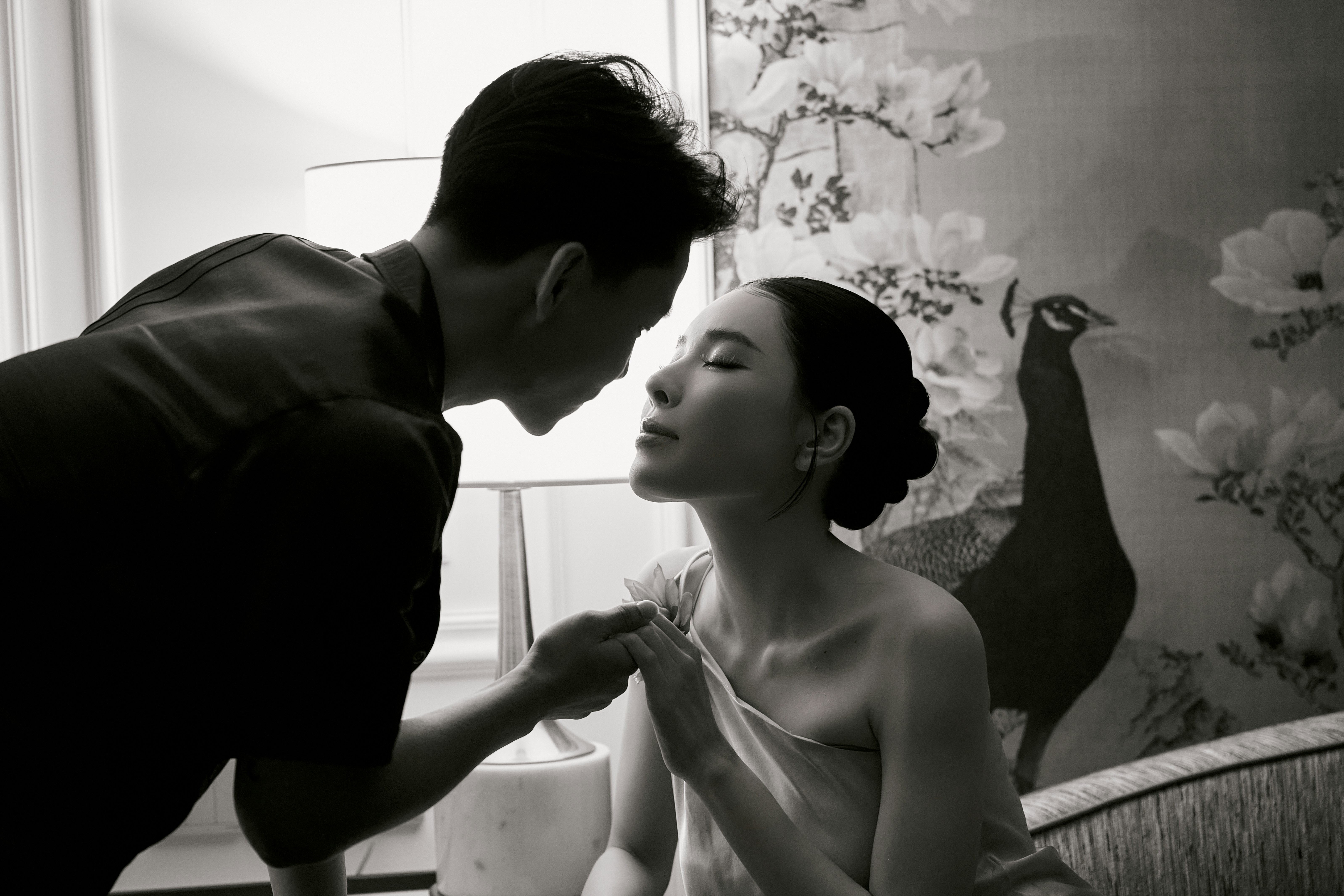 Quiet Union: A Groom Adjusts a Bride’s Veil in Soft Backlight
