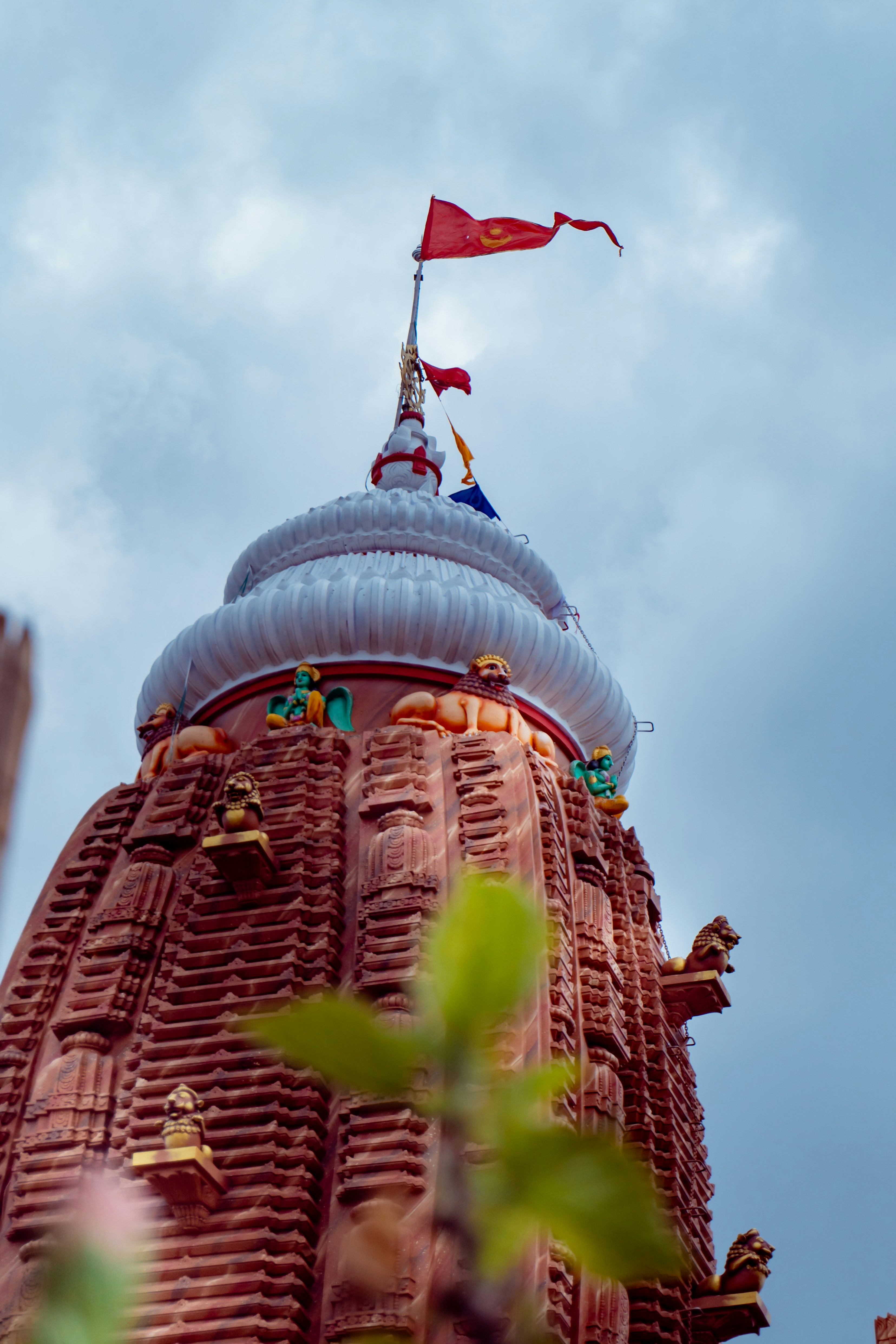Temple Tower crowned by a fluttering red flag against a pale sky