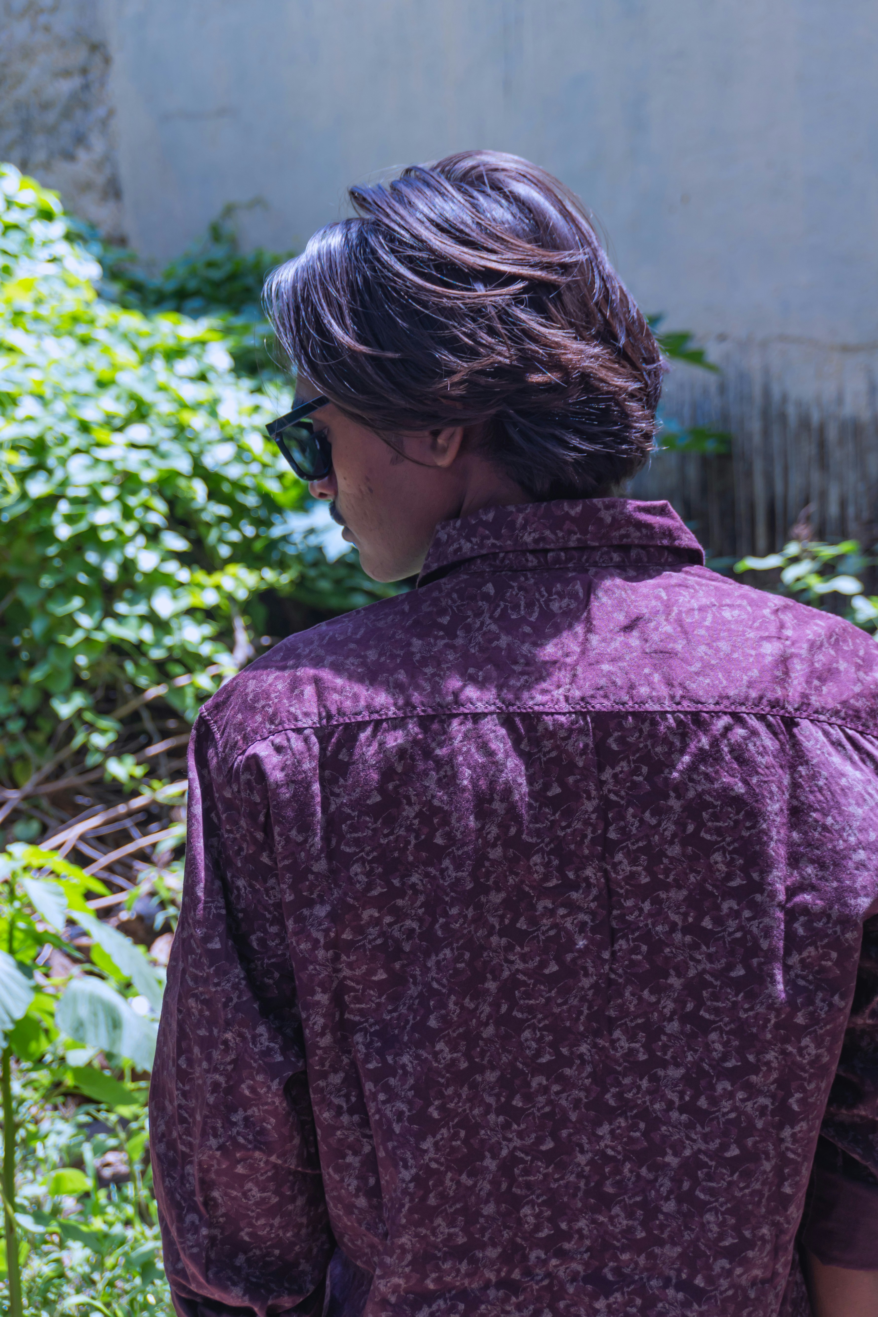 Mid-Garden Portrait: The Back View of a Purple-Patterned Shirt in Sunlit Foliage