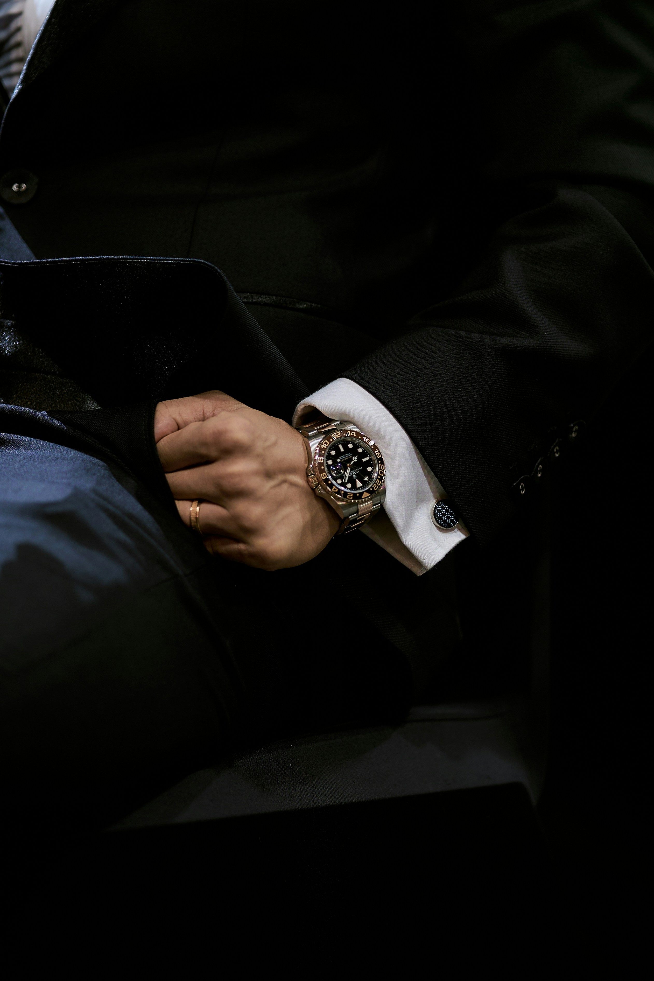 Midnight Elegance: A Polished Wrist Amid Black Suit Layers