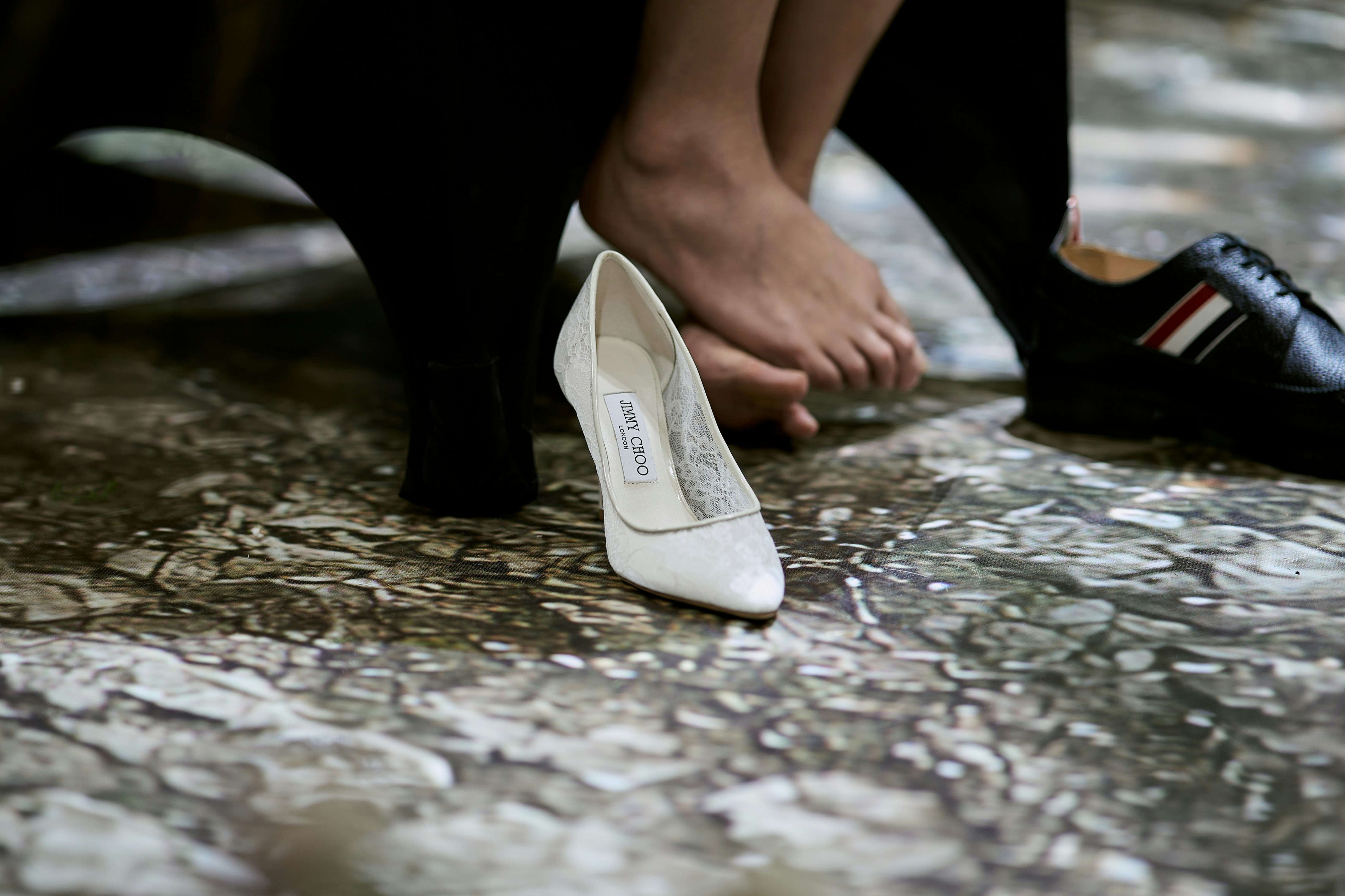 Silhouettes at the Shore: A Quiet Moment with Shoes in Focus