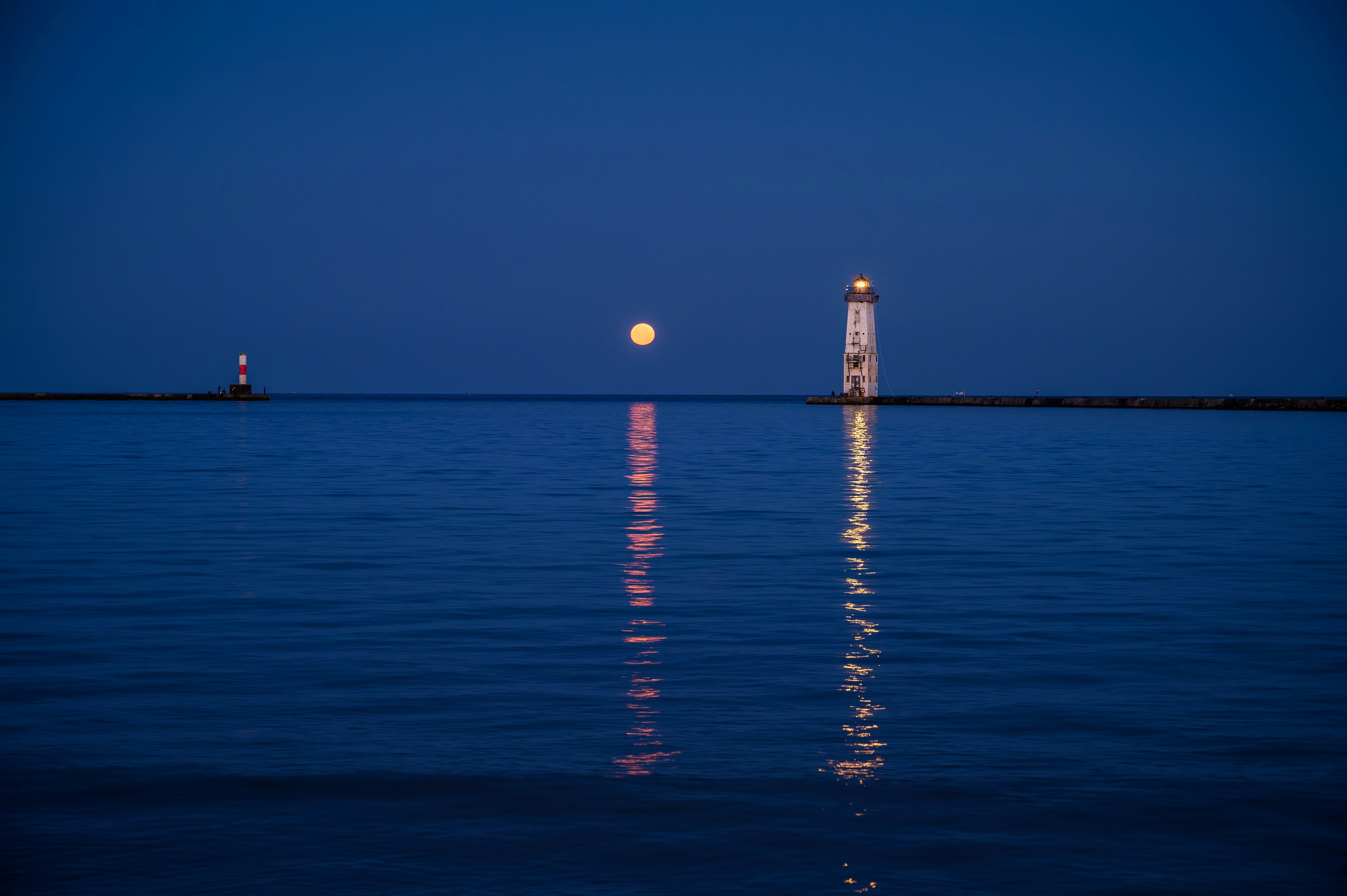 Lunar Beam at Sea: City Lighthouse and Moonlit Wake