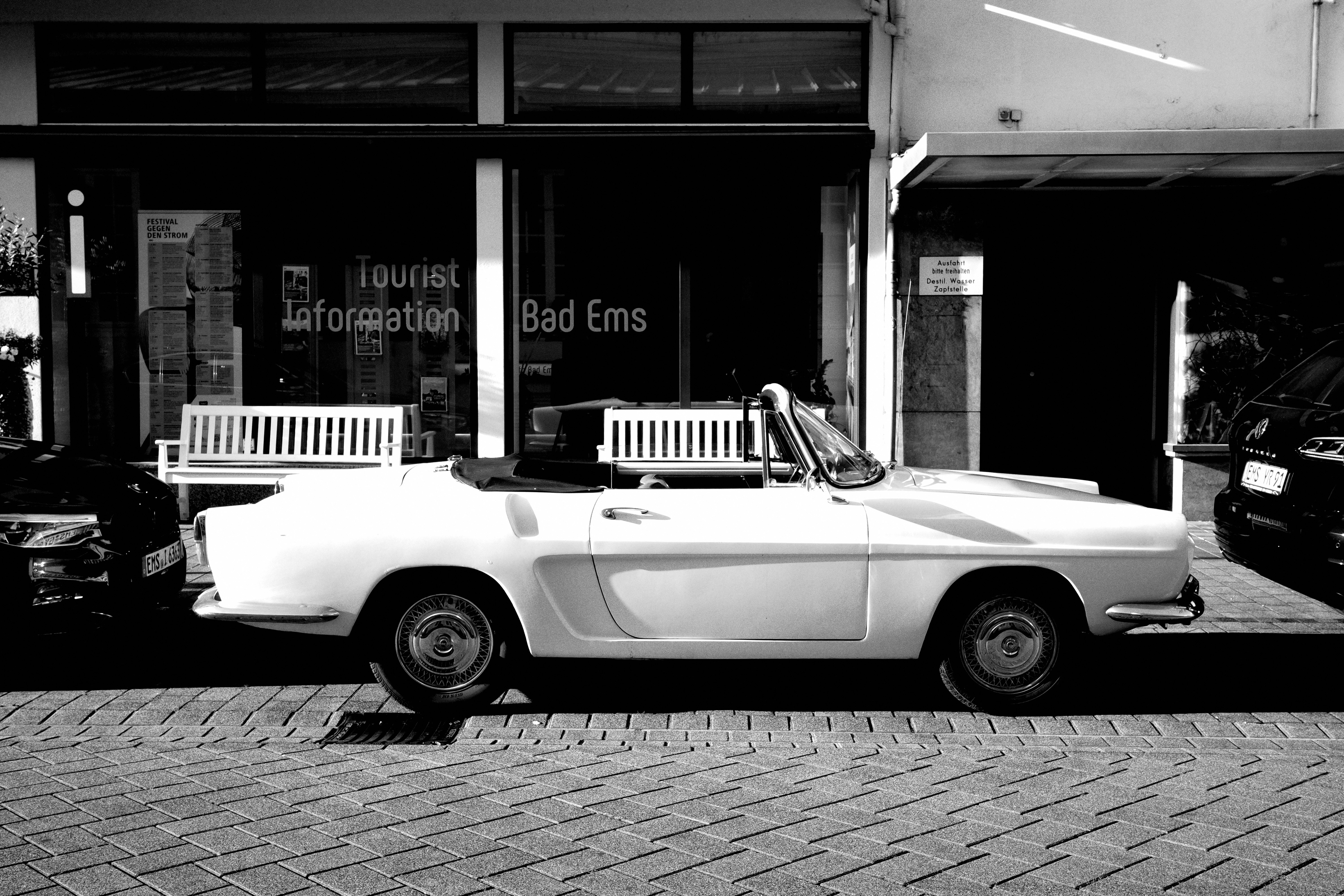 Vintage Convertible on a Quiet Street Between Shopfronts
