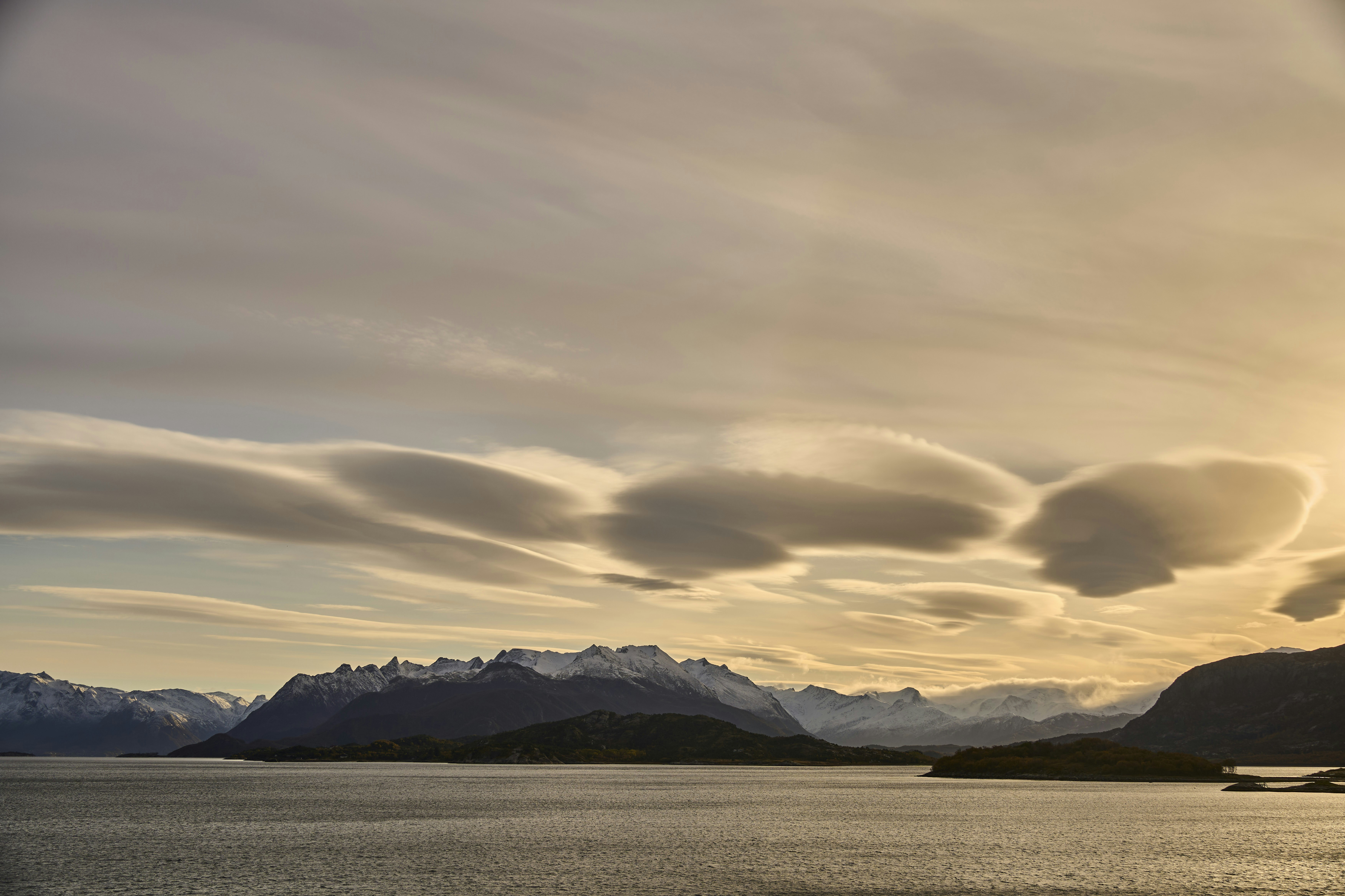 Golden Hour Across the Fjord: Clouds over Snowy Peaks