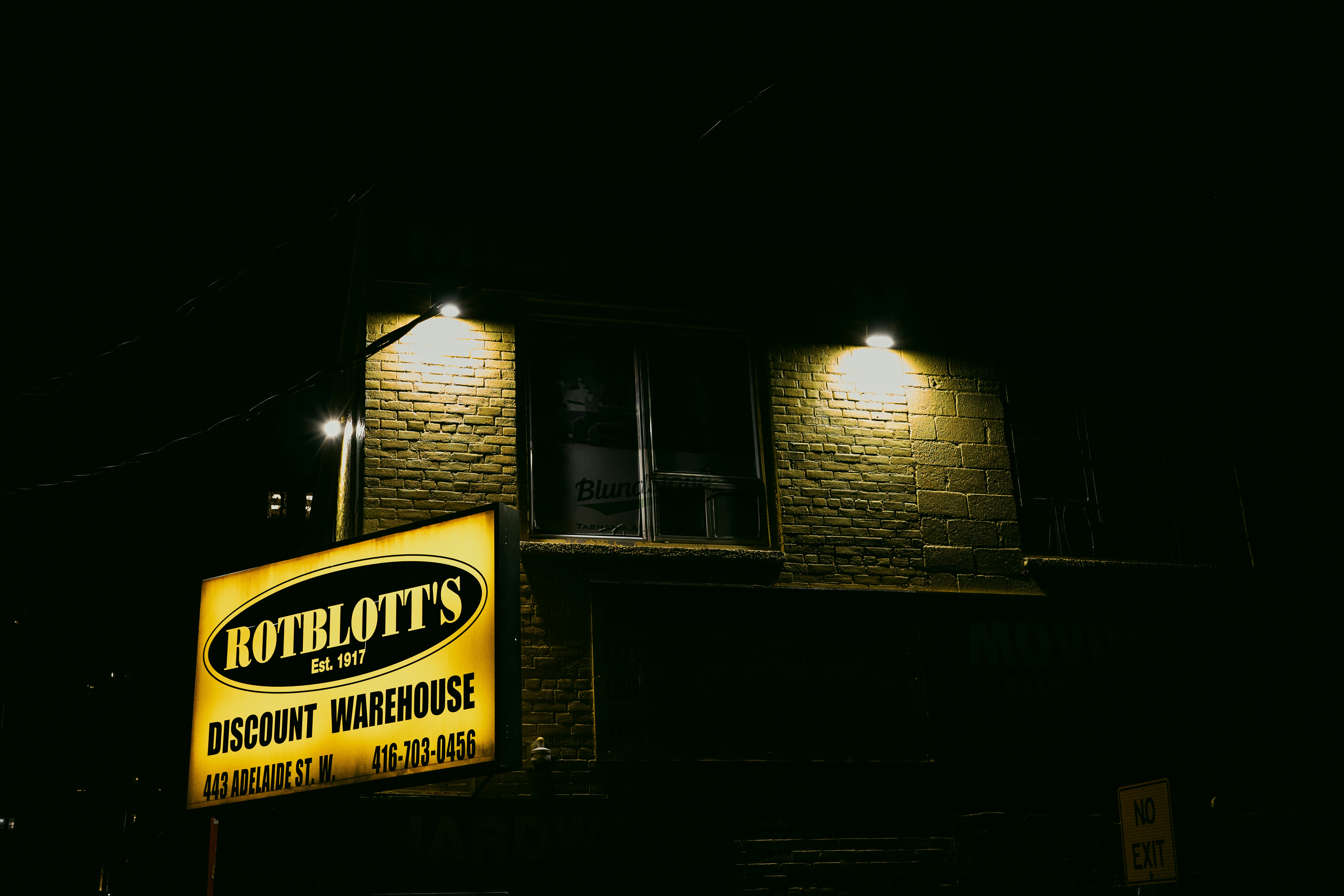 Neon Sign at a Shadowed Discount Warehouse