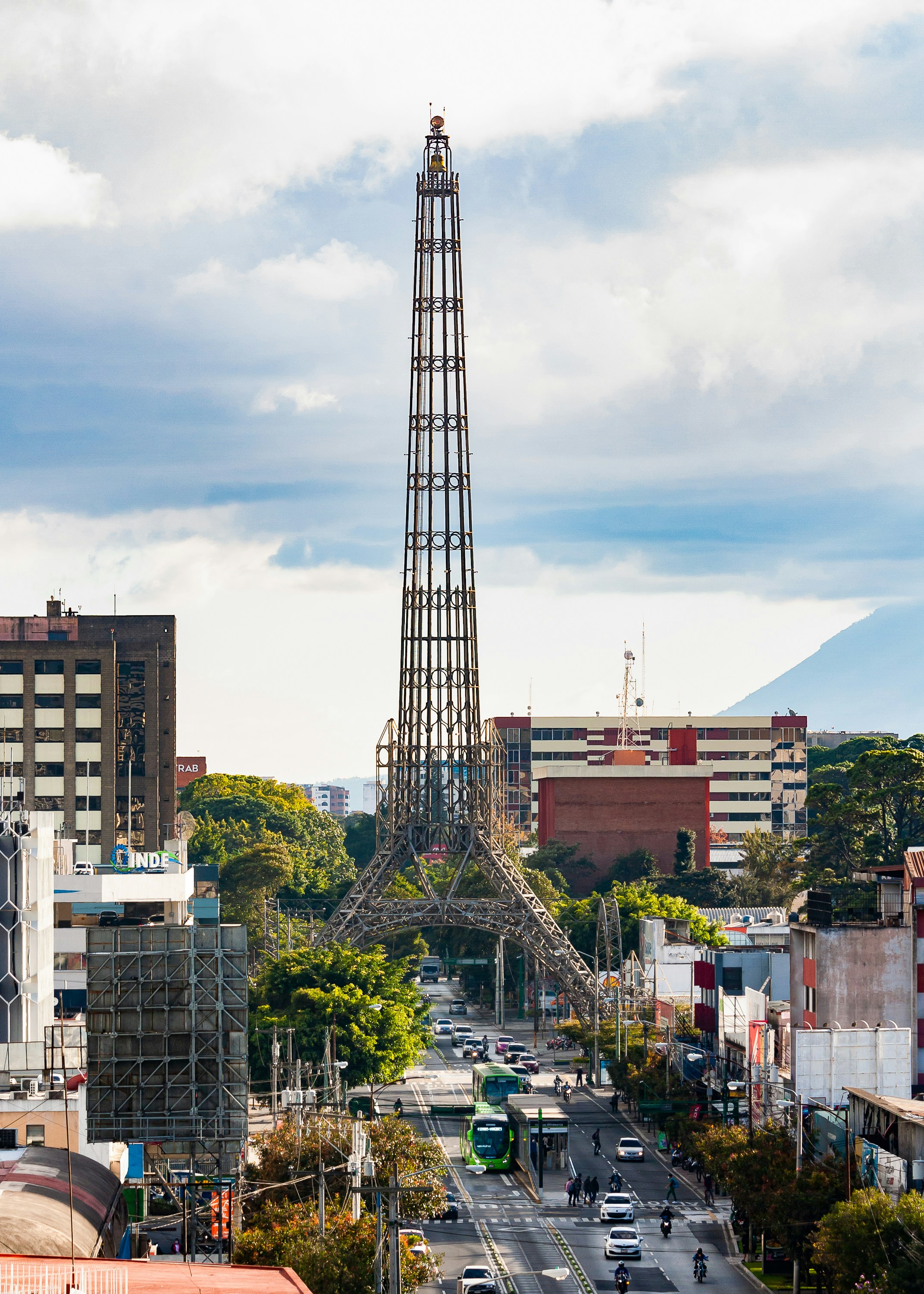 Towered Pulse: A city street unfolds beneath a lattice antenna