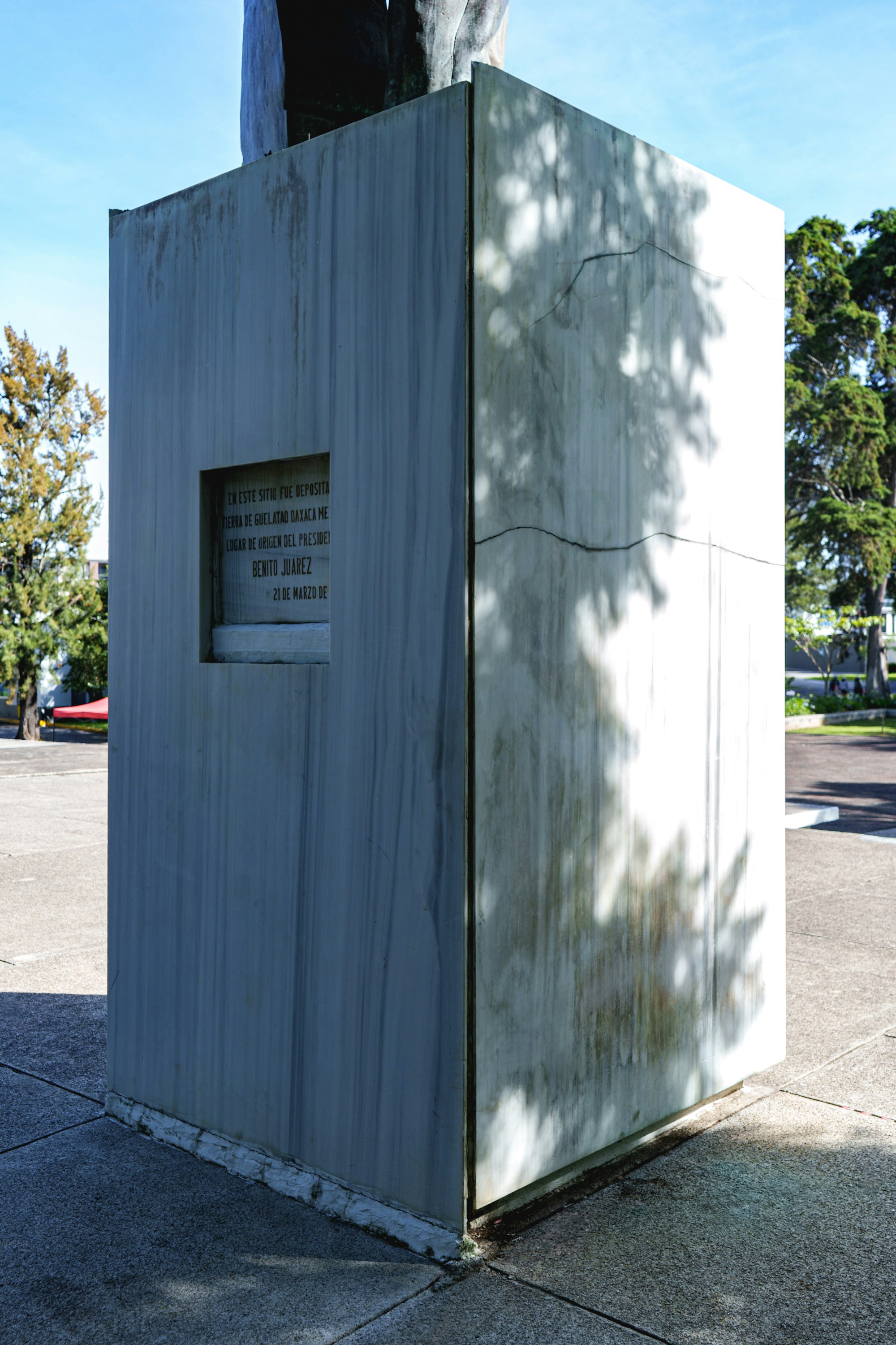 Monument Framed by Shadow: A Vertical Marble Obelisk in Sunlit Plaza