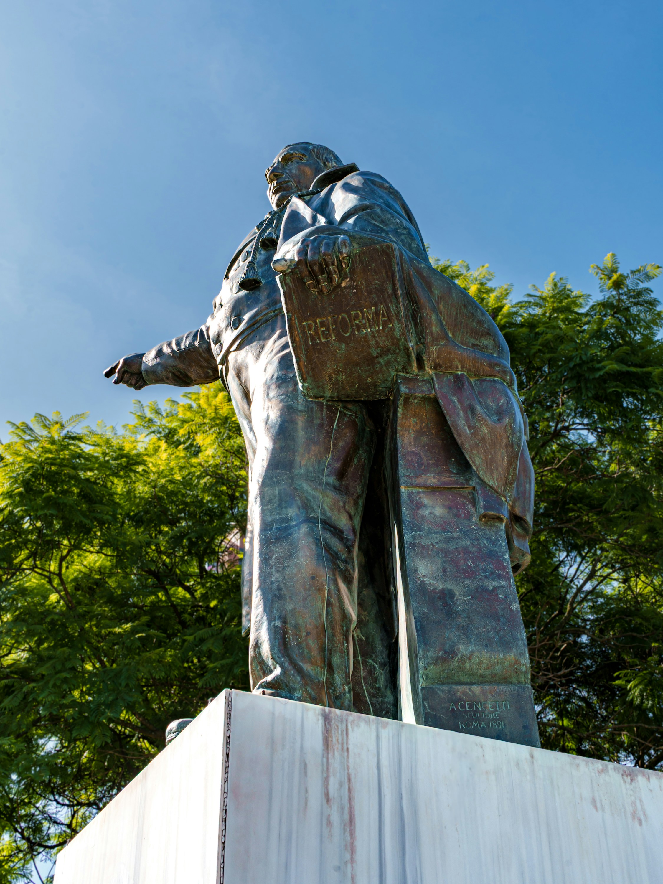 Guardian of the Plaza: A Weathered Statue Reaching Toward the Sky