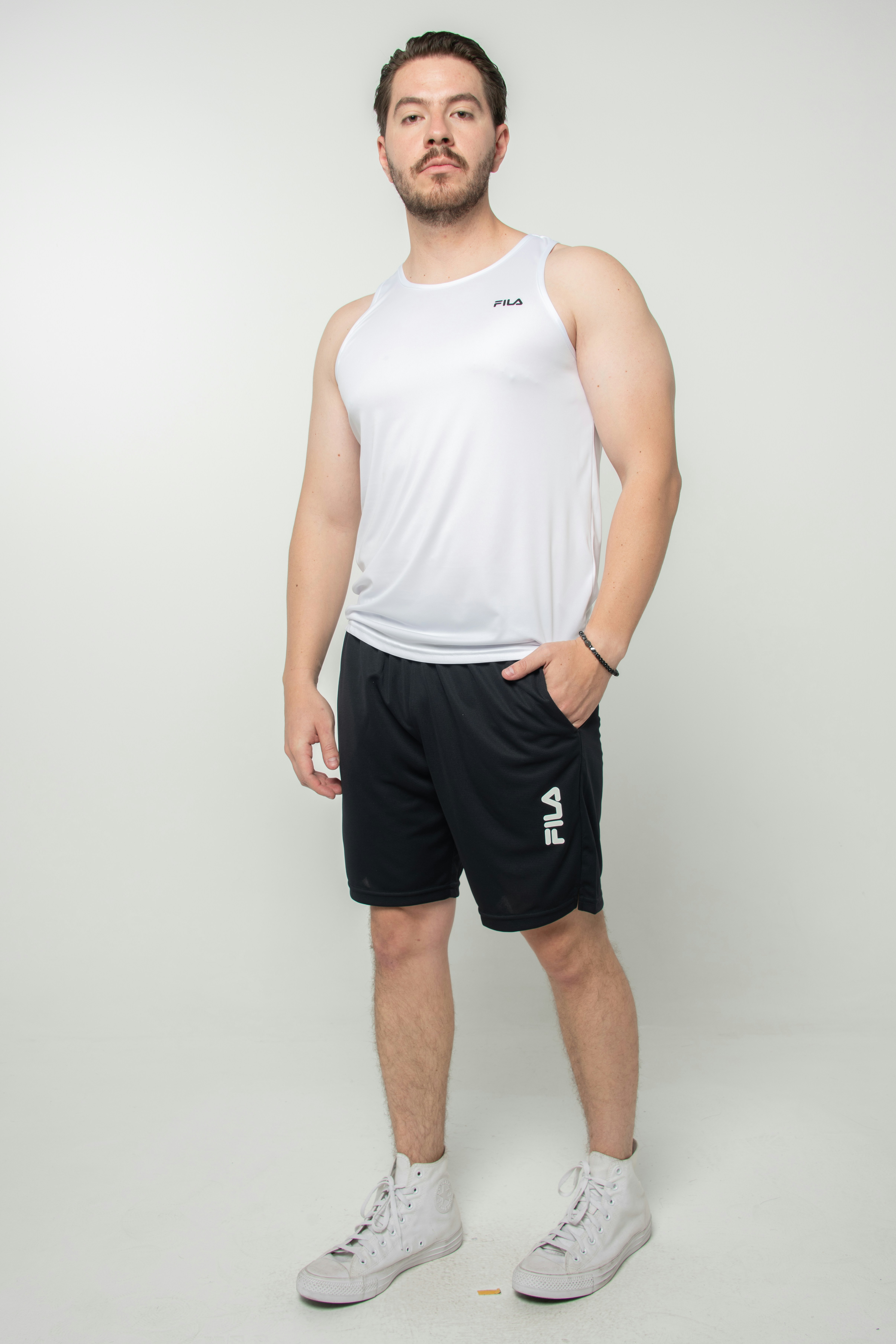 Athletic Confidence: A poised model in a white sleeveless top and black shorts