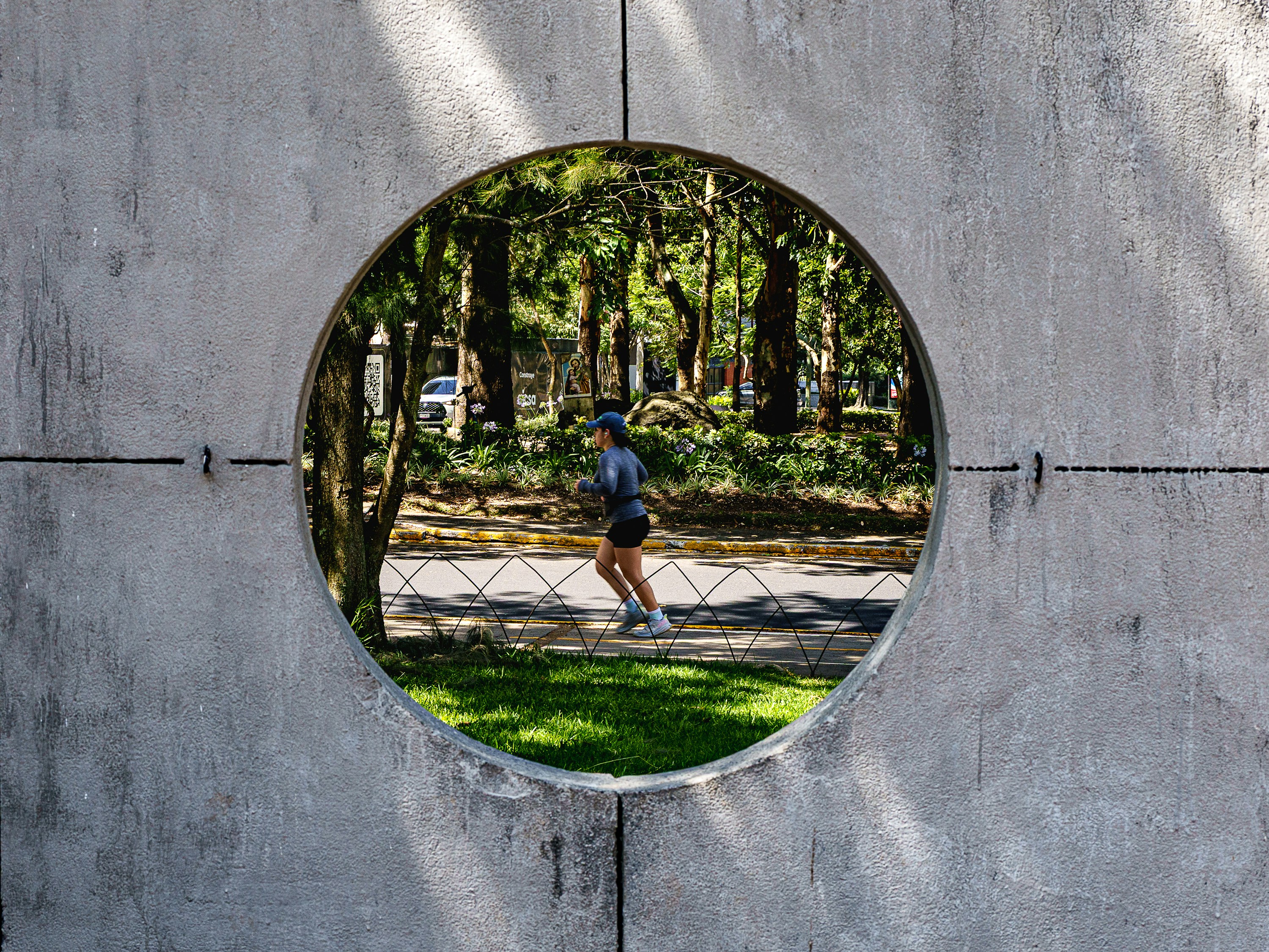 Runner in a Circular Window: A Moment of Motion Through Concrete