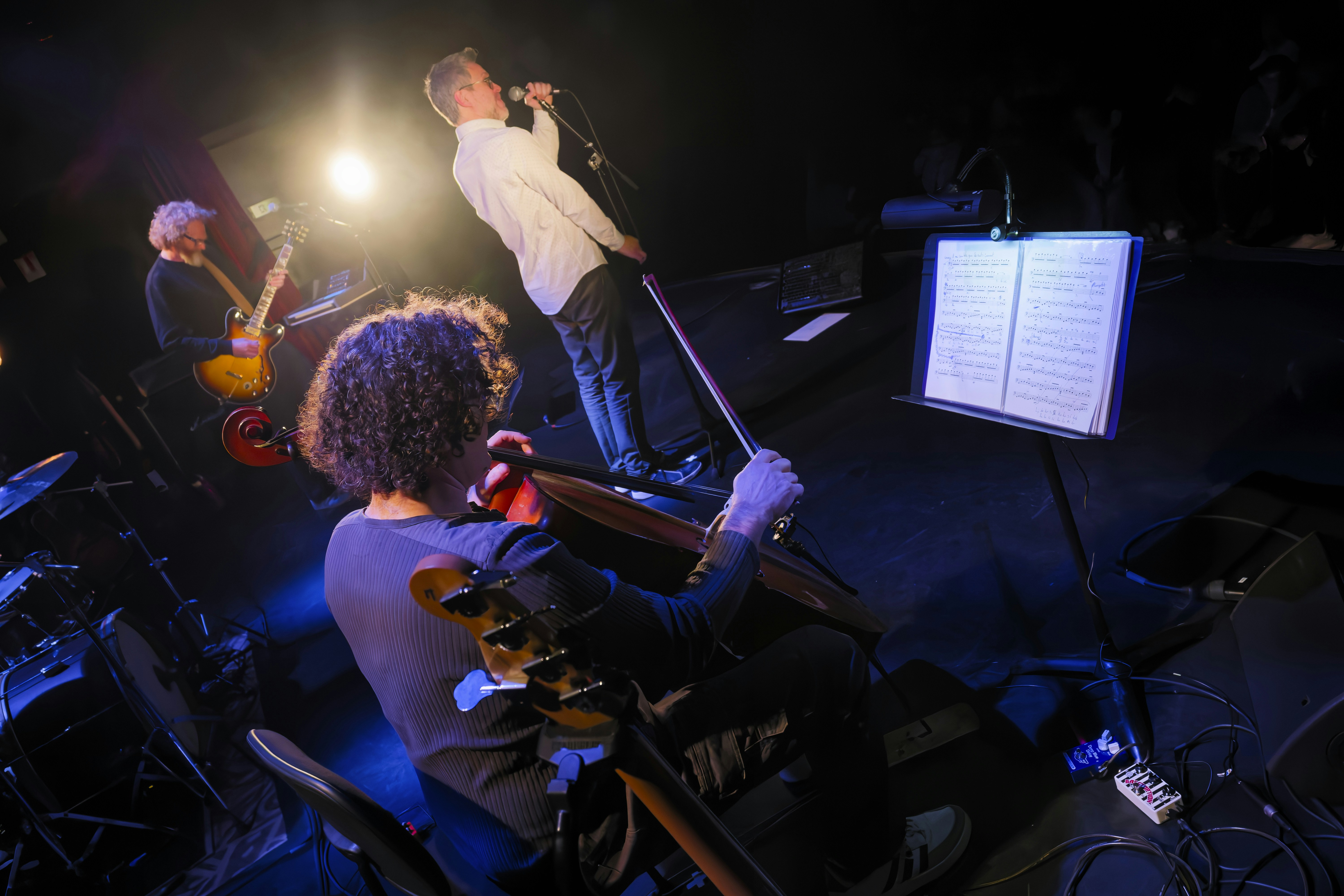 Midnight Crescendo: The Lead Singer Bends Toward the Mic as the Band Energizes