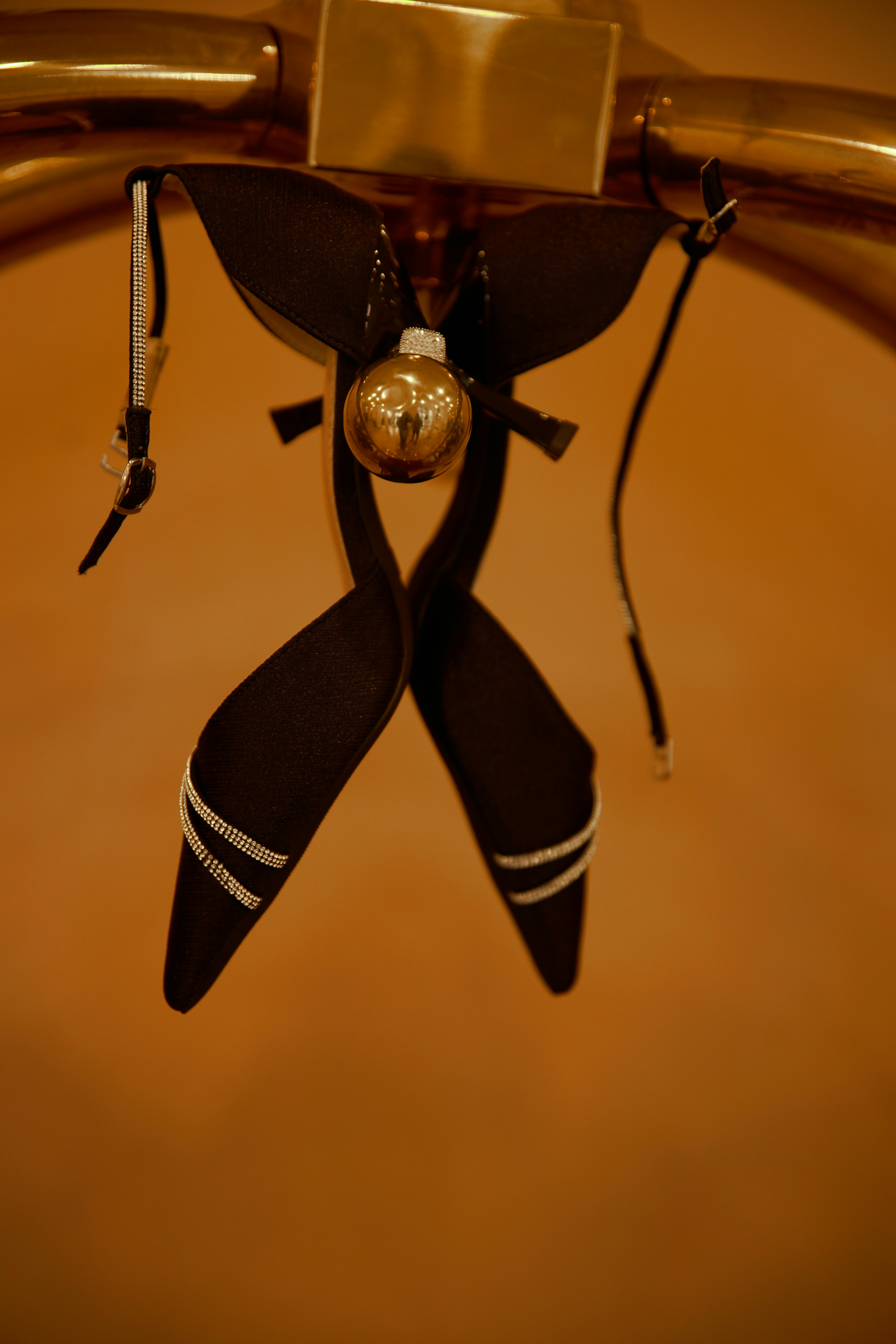 Suspended Bow: a close-up of a black satin bow and metallic orb