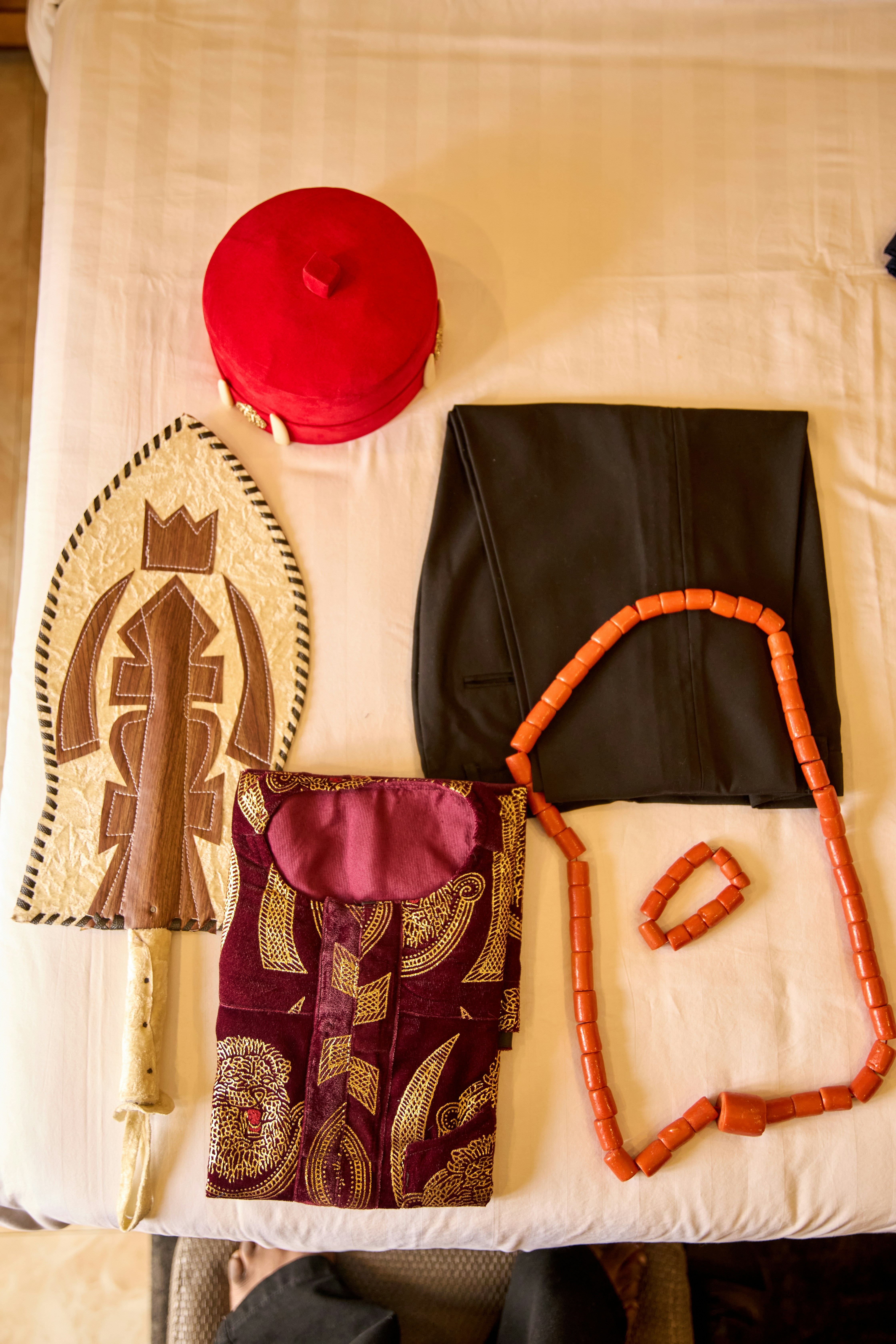 A Still Life of Textiles and Accessories Cast Across a Bed