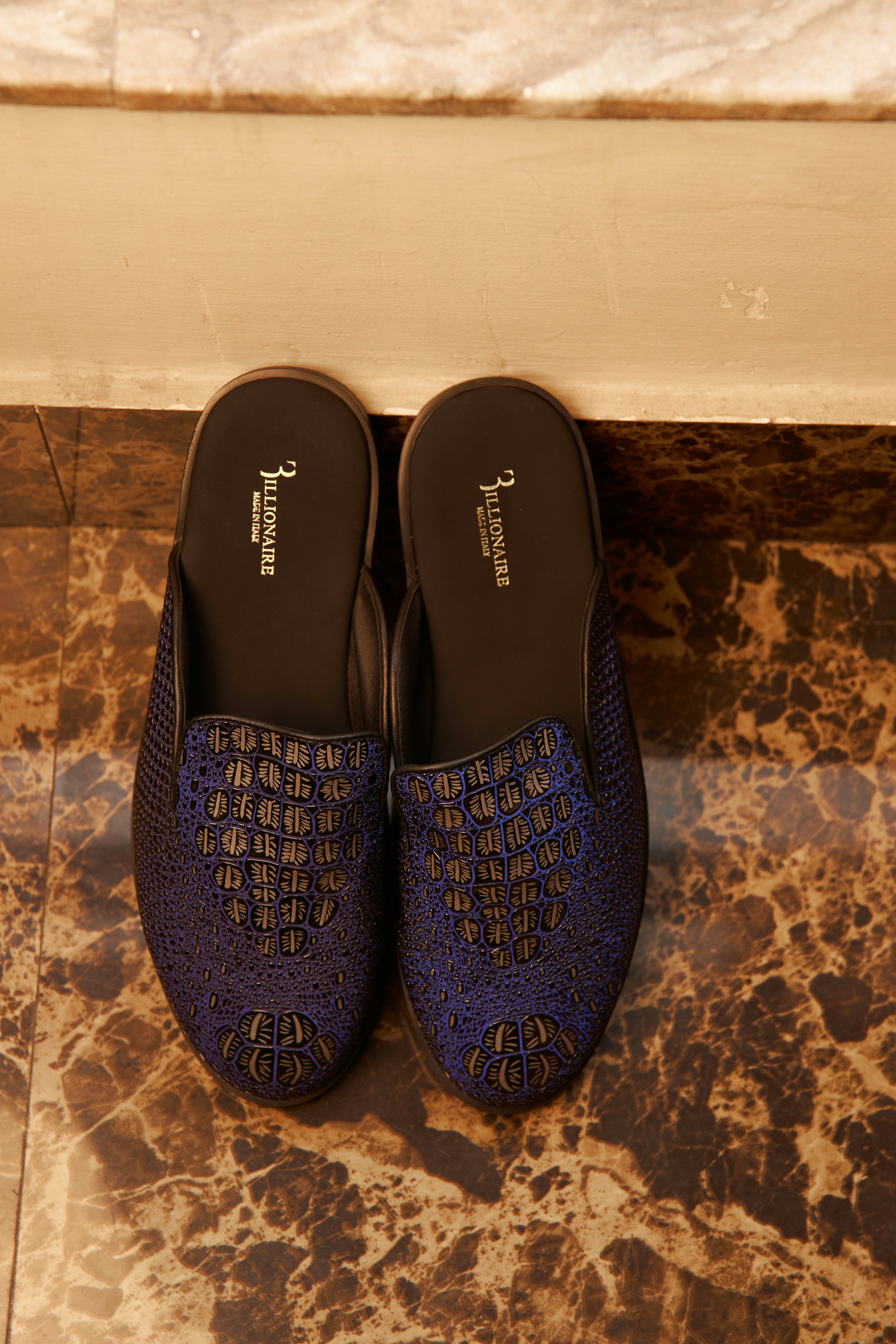 Blue woven slip-ons resting on a marble-tiled floor at the doorway