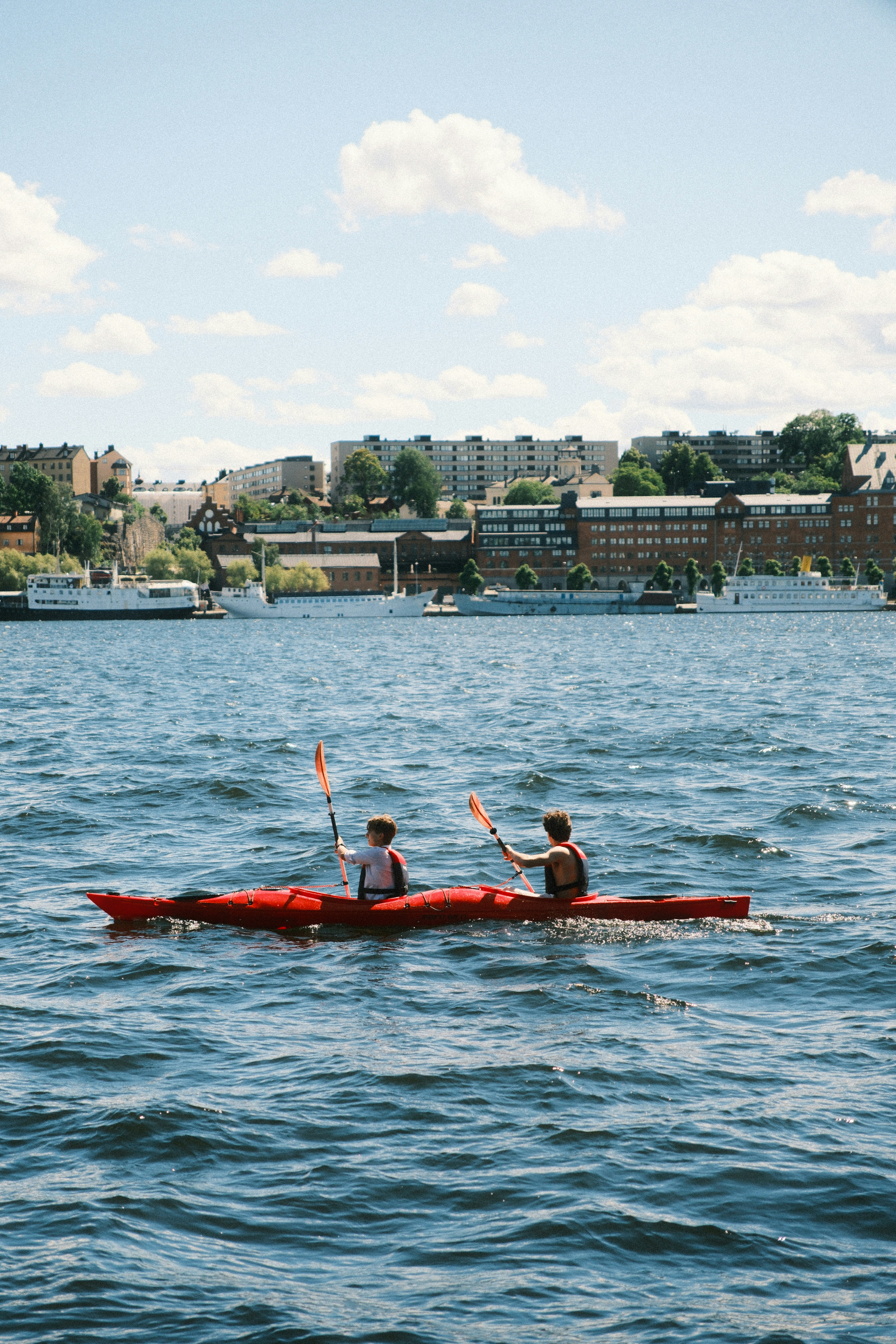 Red Kayak Duo Slicing Through a Quiet Waterfront
