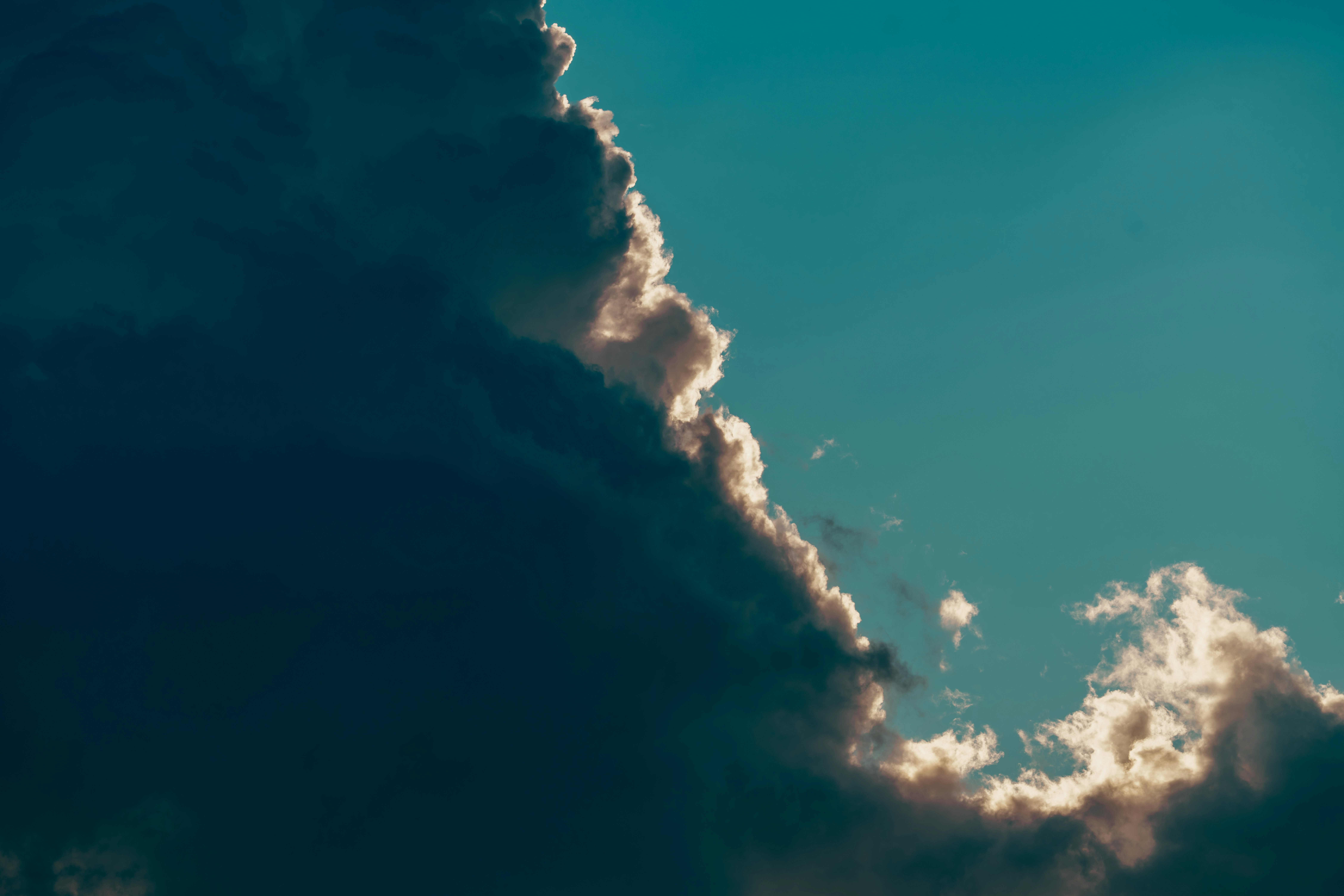 Edge of the Sky: Sunlit Cloud Over a Turquoise Crest