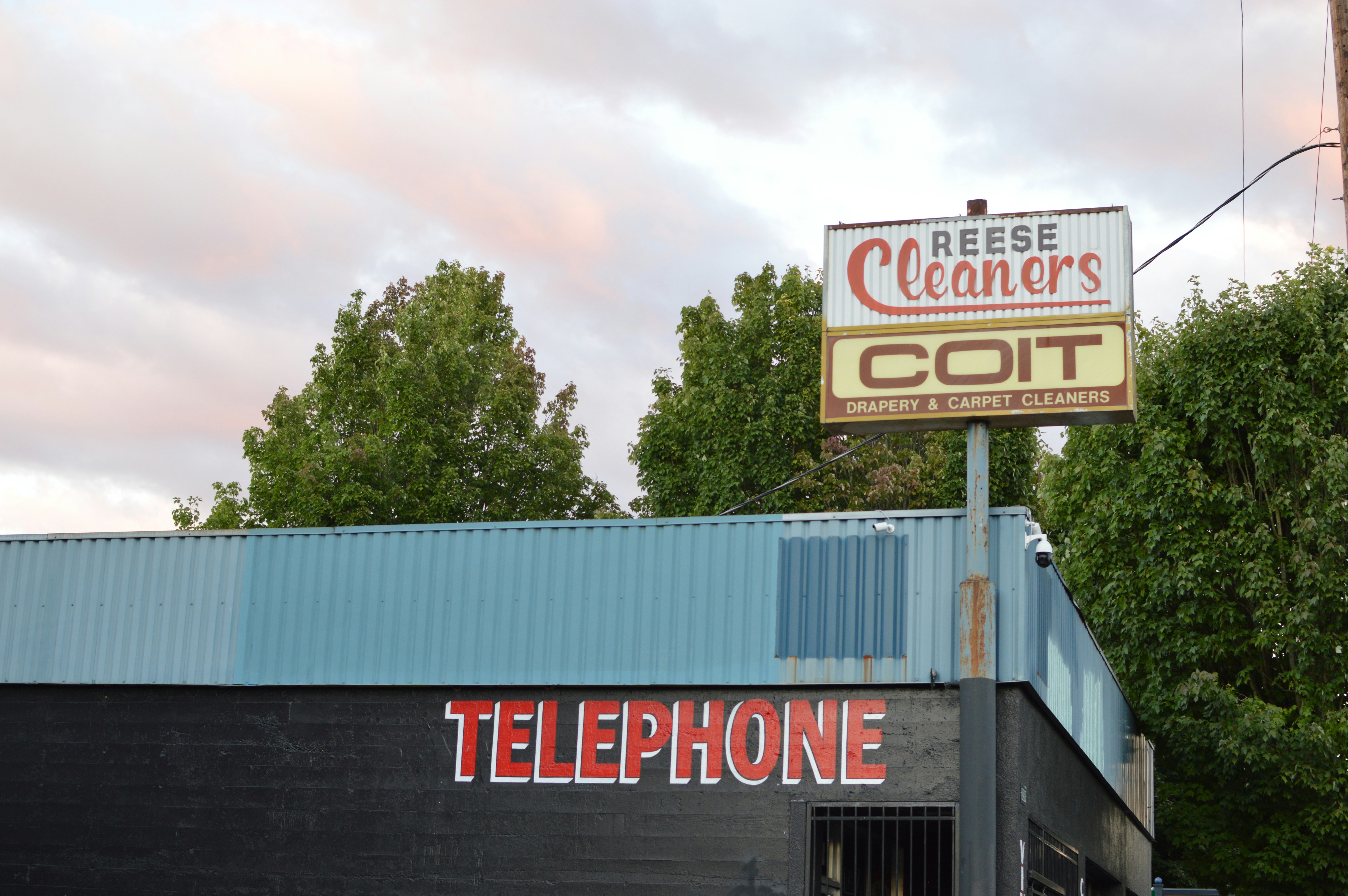 Neon Sign and Weathered Signage above a Blue-roofed storefront