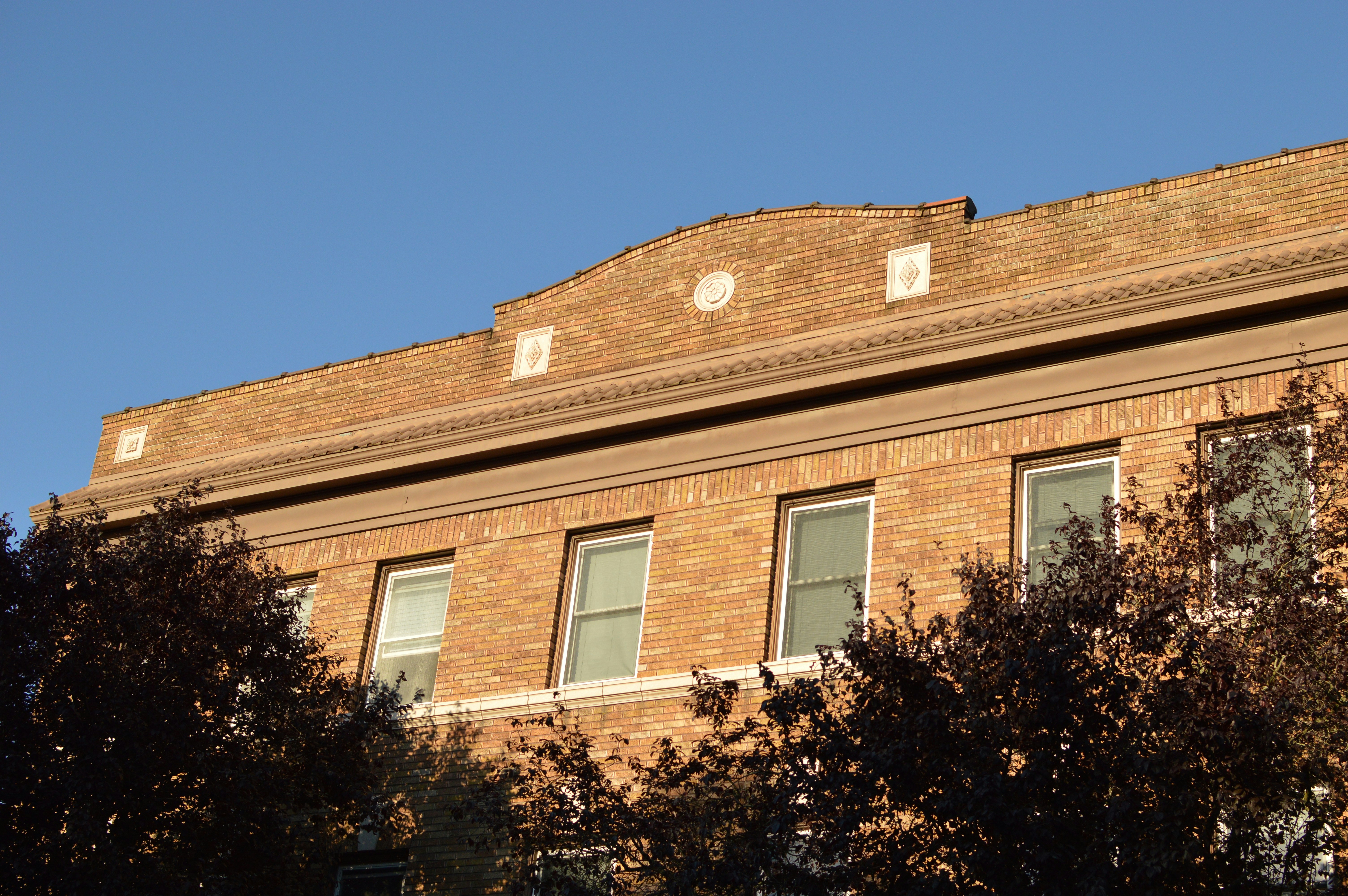 Brick Facade Under Clear Sky: A Corner of Urban Architecture