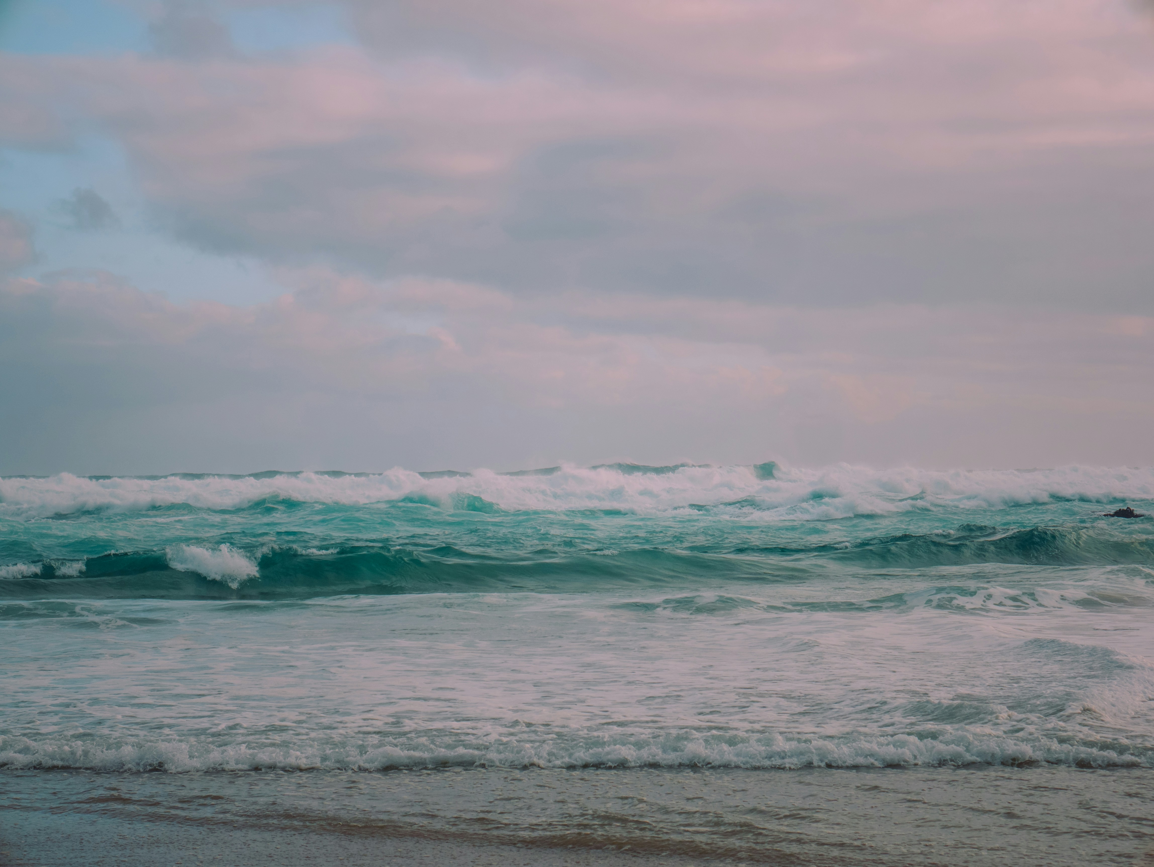 Horizon on Soft Turquoise: Waves Rolling into a Quiet Beach