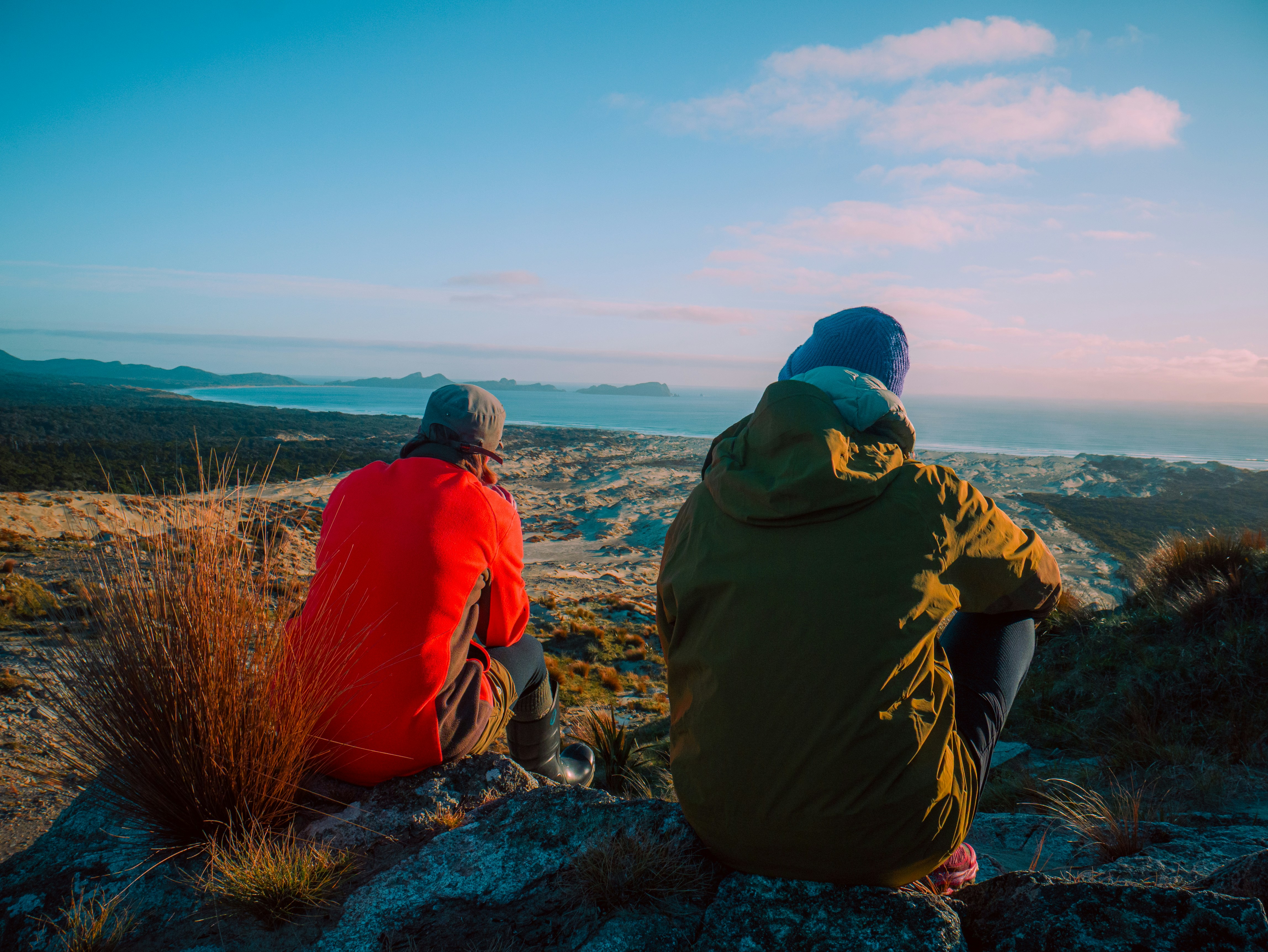 Two hikers watch the coastal horizon from a windswept bluff