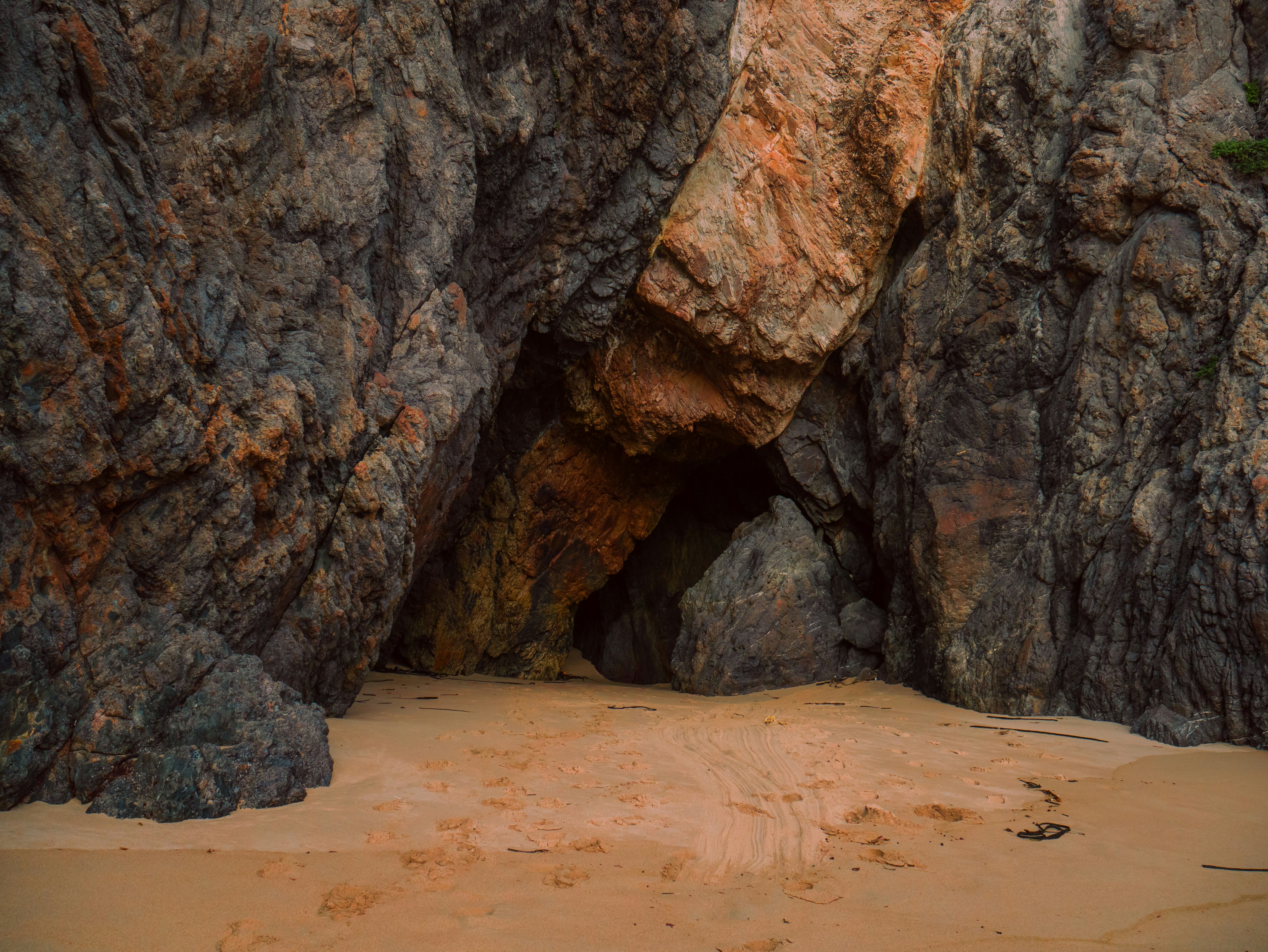 Rimward Entrance: A Quiet Beach Cave Nestled Between rugged basalt cliffs