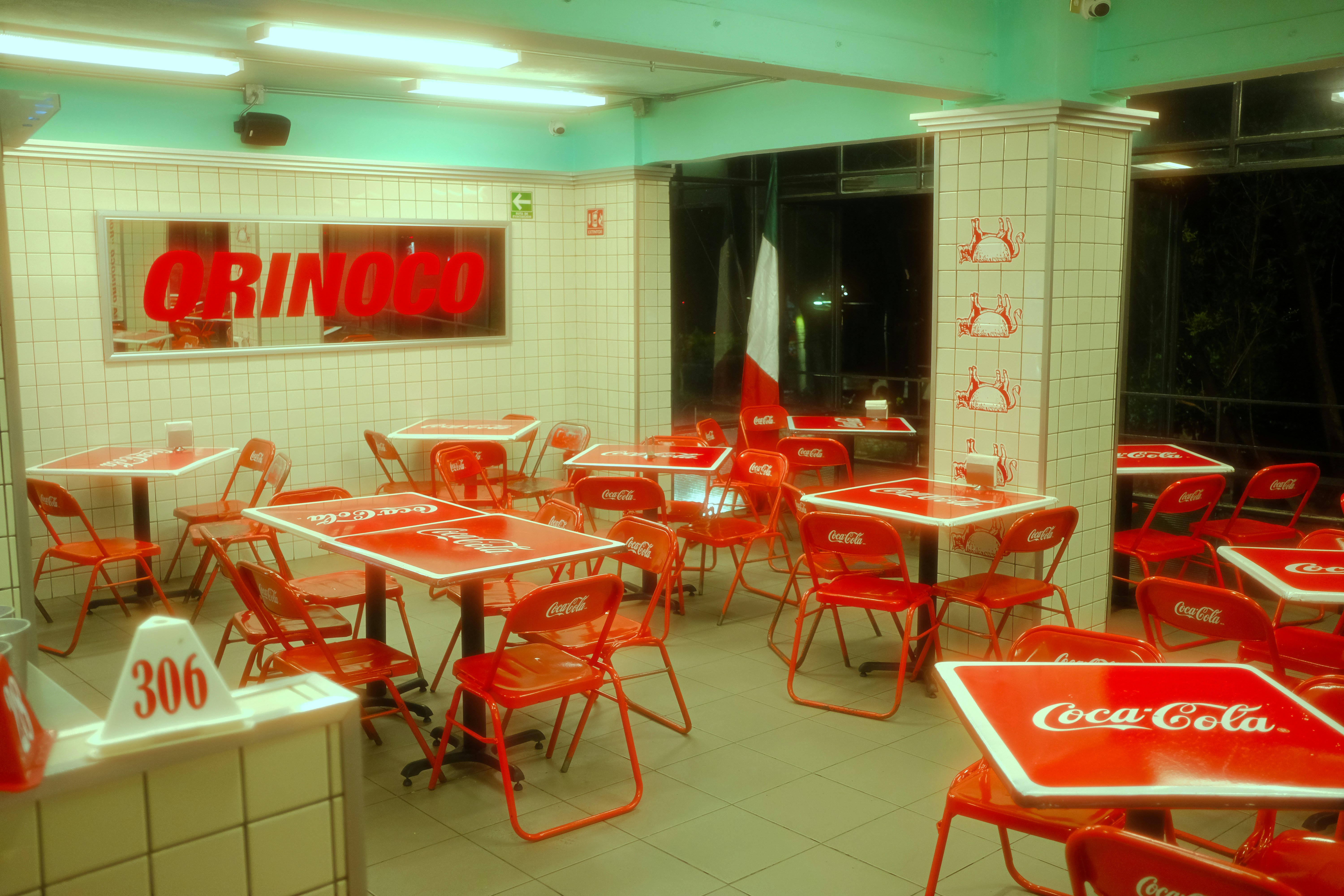 Retro Coca-Cola Diner: Neon Red Tables and Vintage Seating