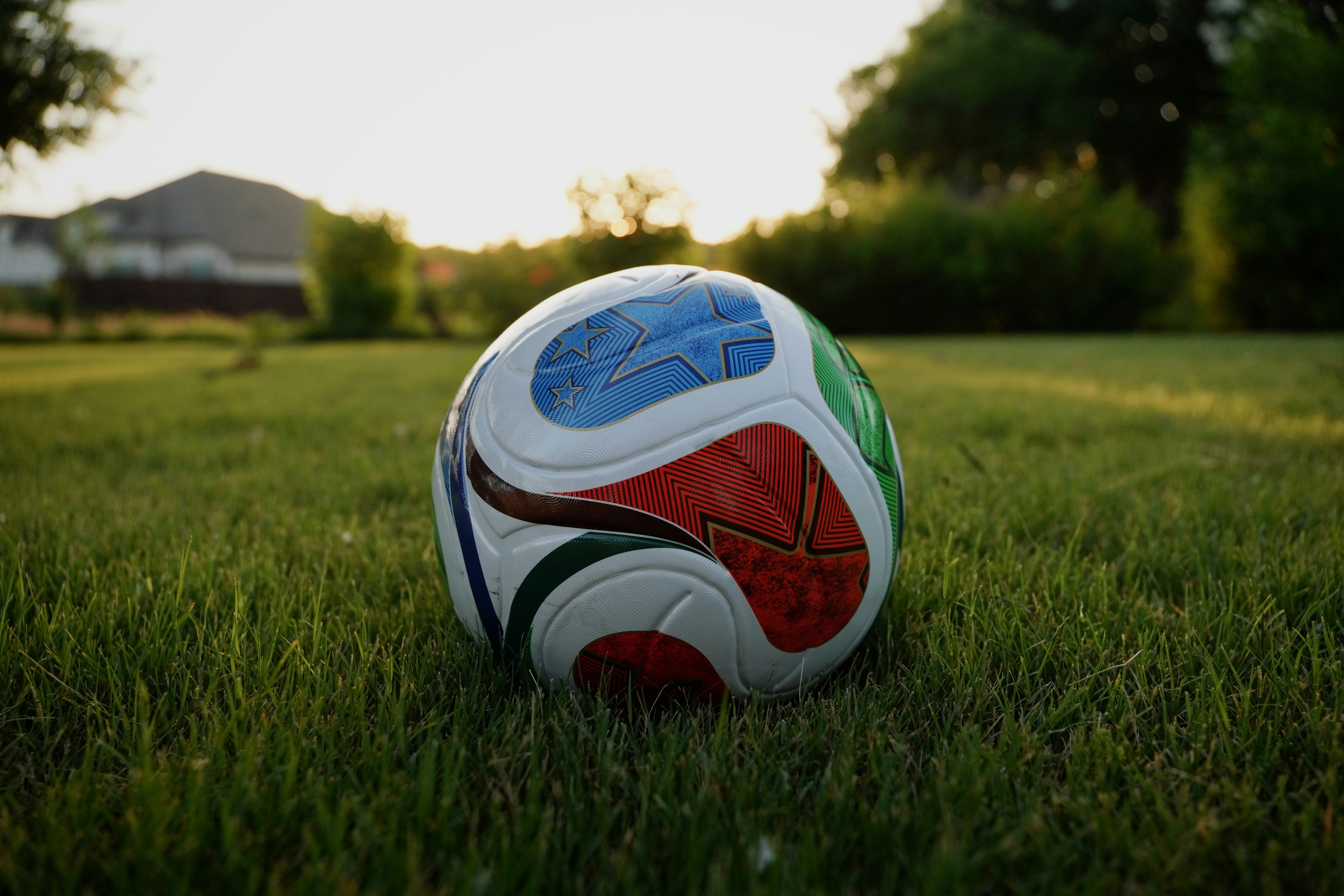 Close-Up of a Multicolored Soccer Ball Resting on Lawn at Sunset