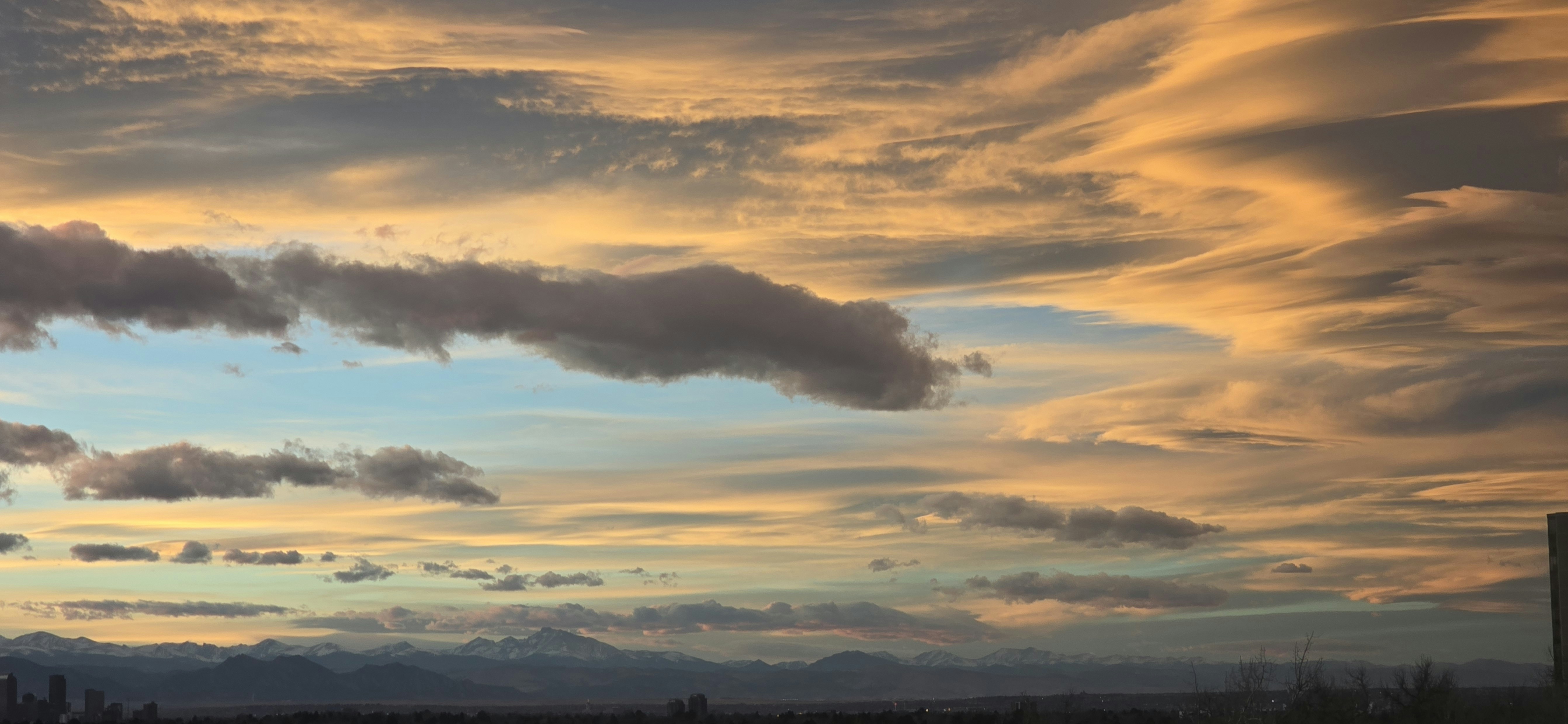 Cloud Currents Over a Distant Skyline at Sunset