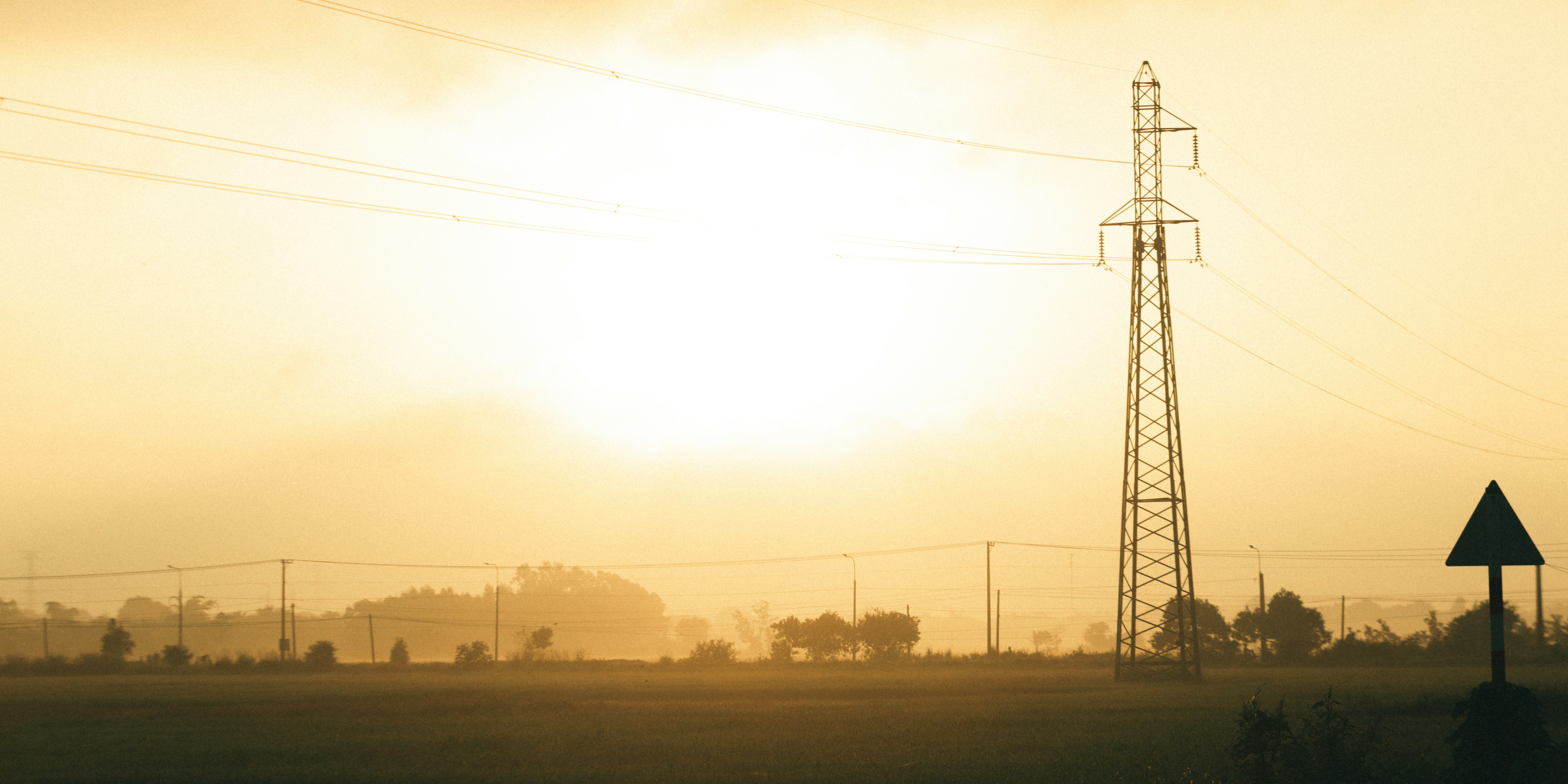 Sun-Drenched Horizon with Transmission Towers at Dawn