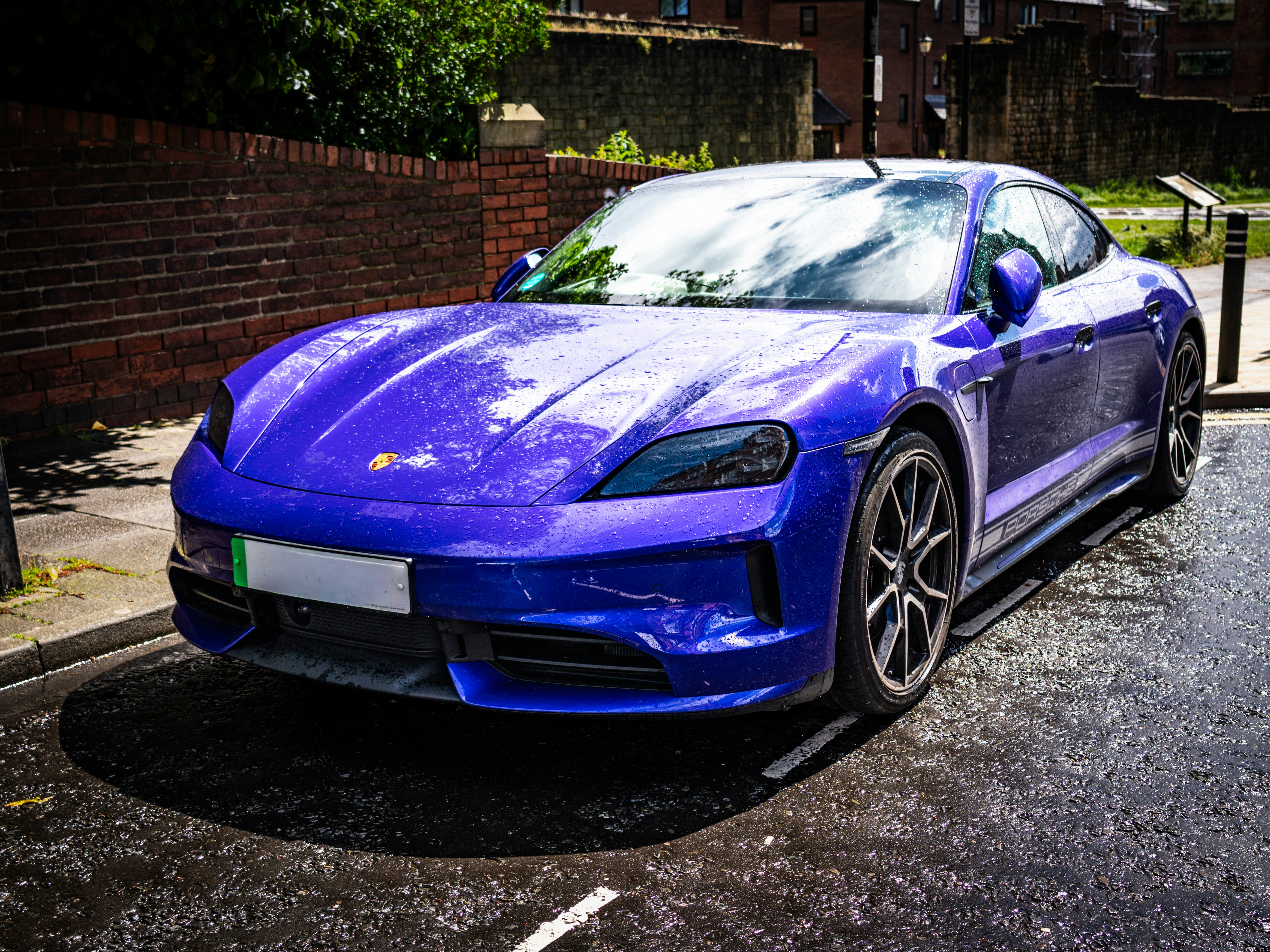 Electric Royalty: A Blue Porsche Stationed Under Urban Sunlight