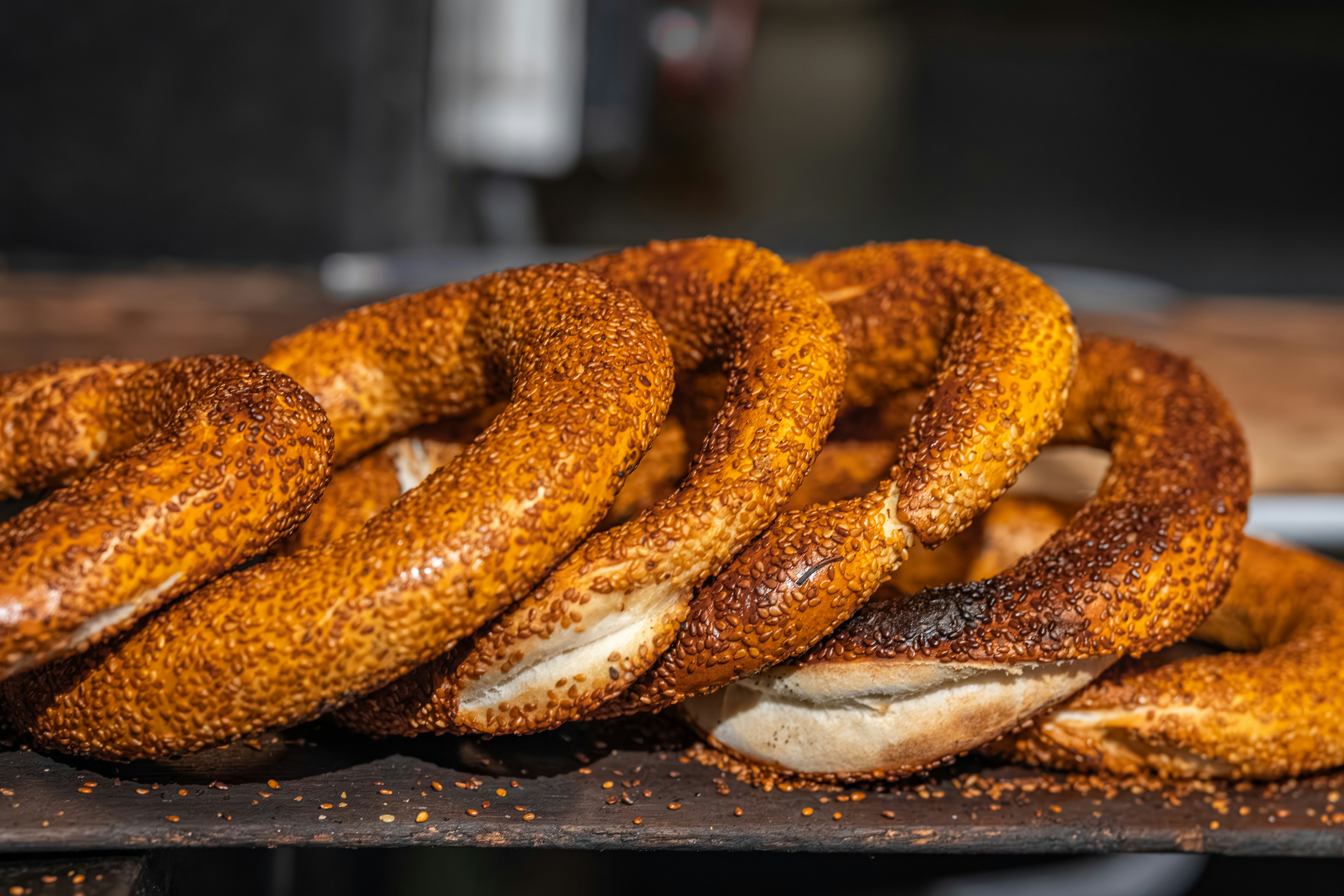 Golden Ringed Crusts: A Row of Sesame-Sprinkled Bagels on a Dark Marble Slate