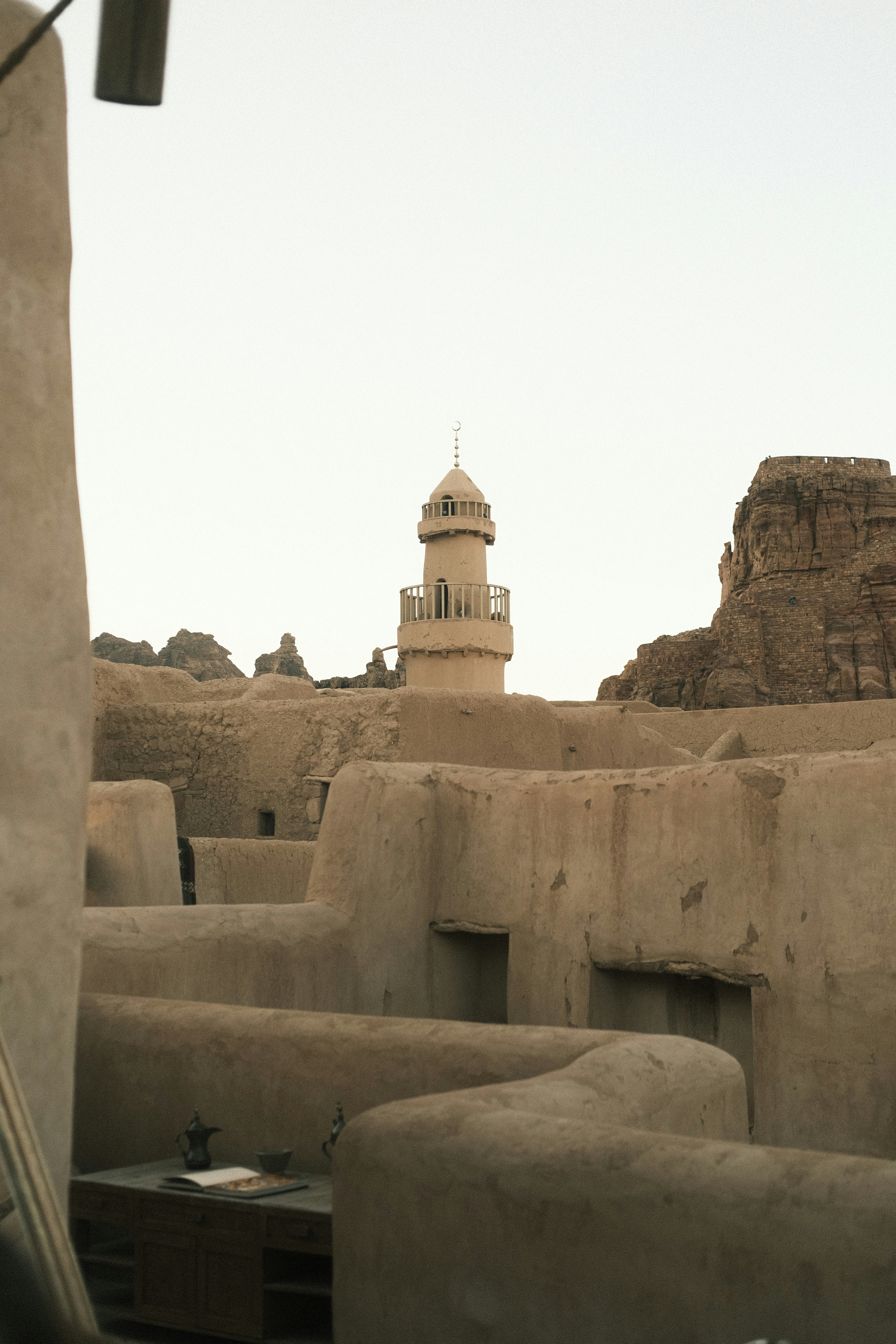 Desert fortress silhouette: a solitary lantern tower rising above sunlit adobe walls