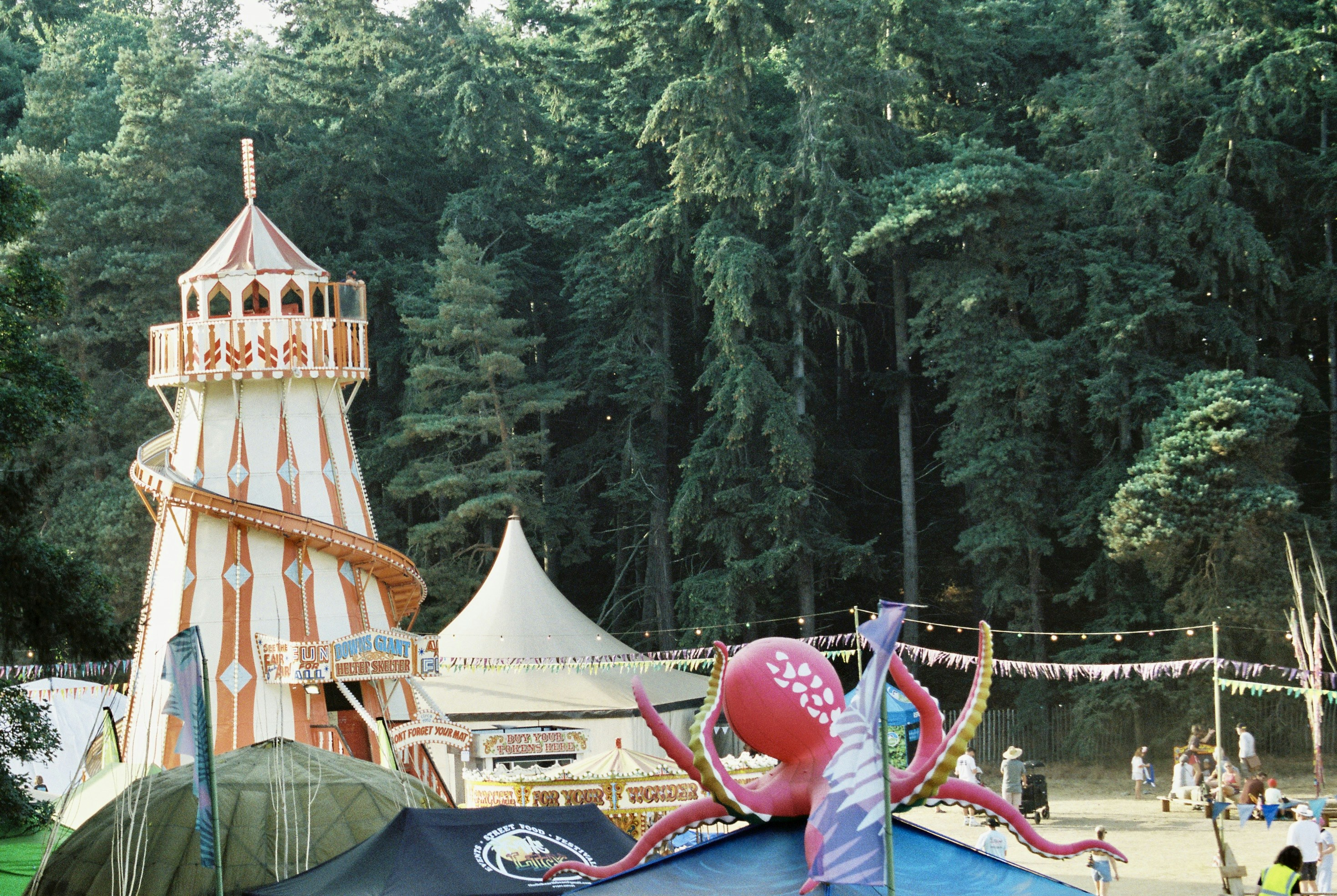 Spiral Scoop of Fun: A Whimsical Carnival Tower Guards the Tent Rows