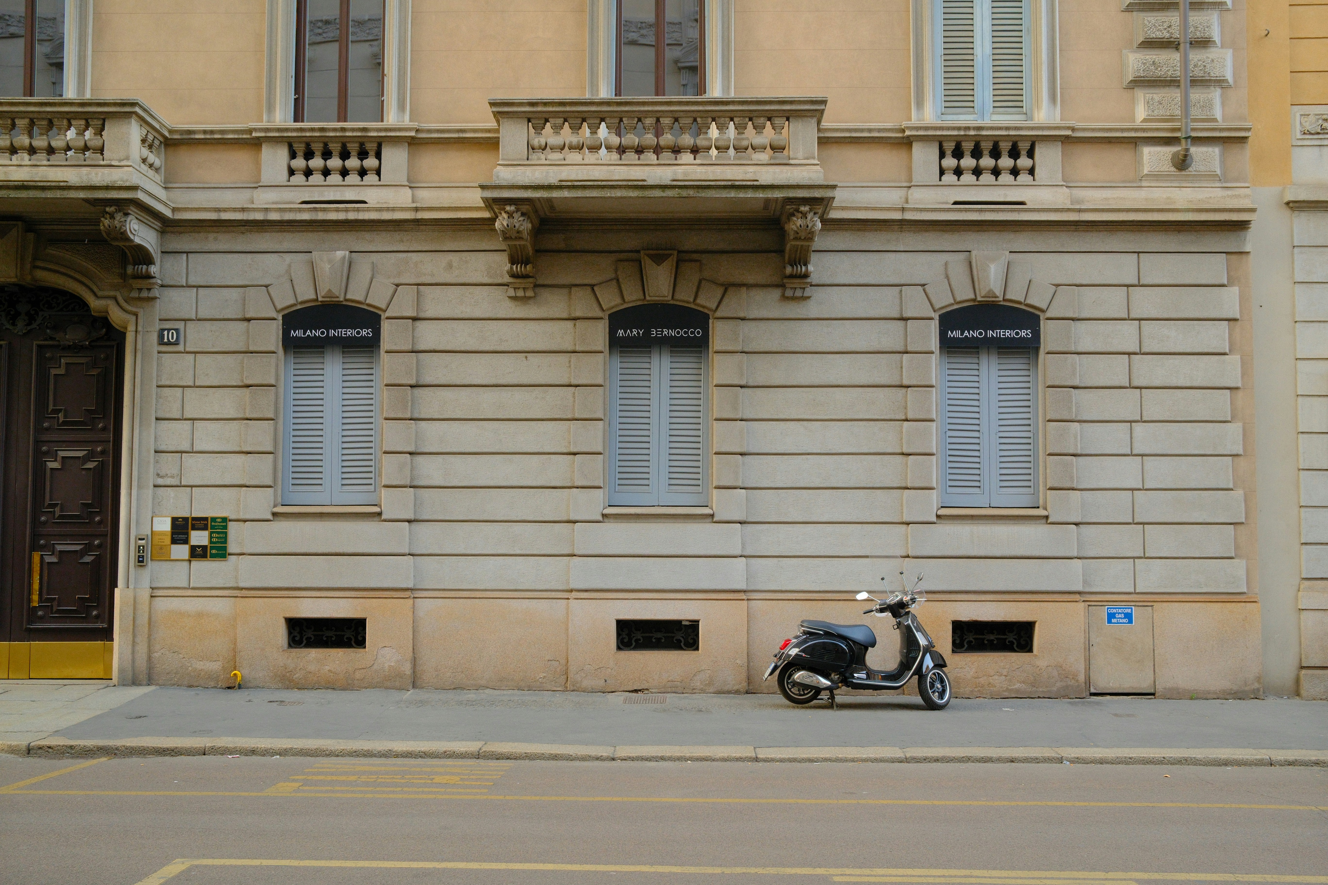 Streetwise Silence: A Scooter Resting Before a Historic Facade