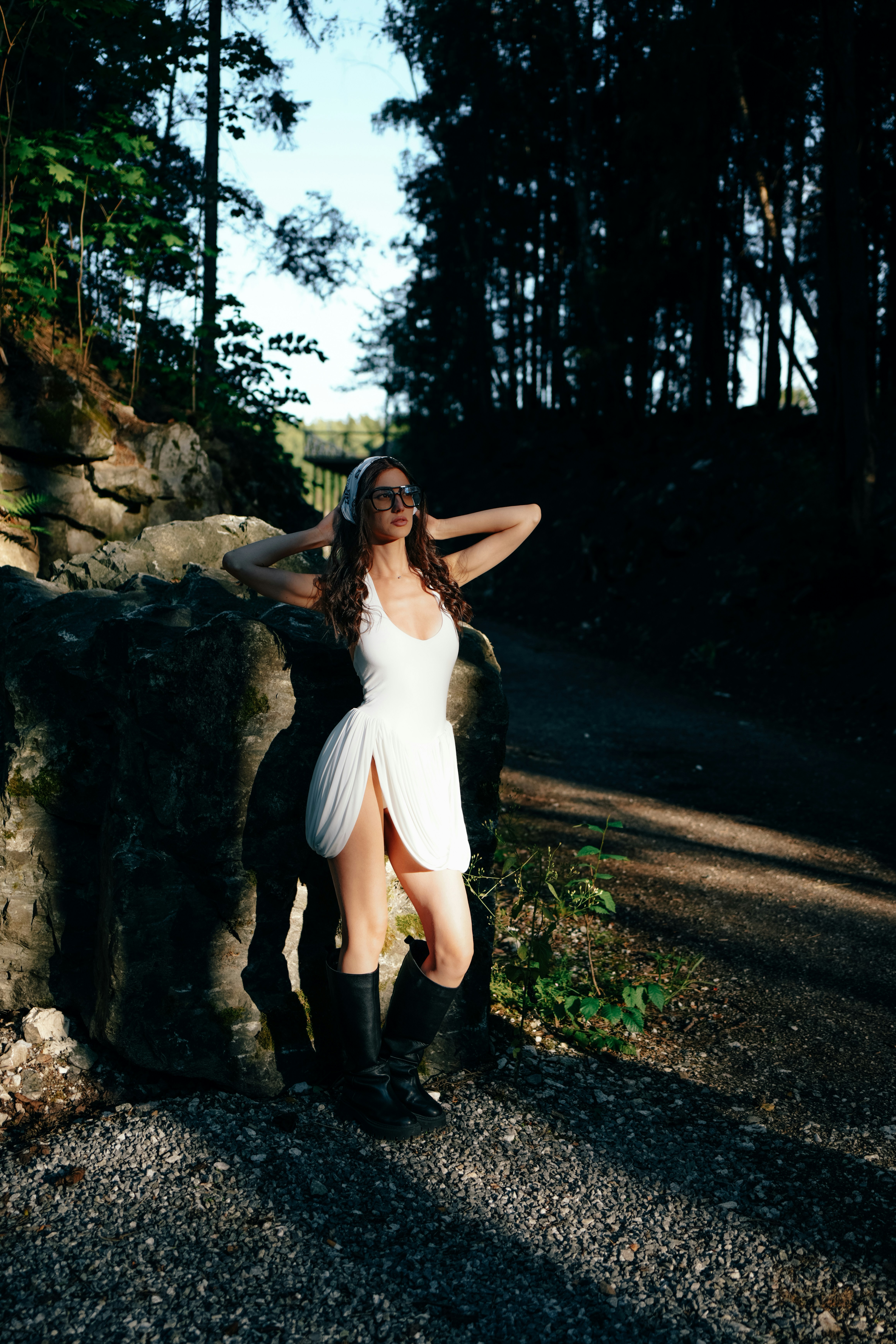 White-draped Neonine: A Sunlit Pose by the Stone Wall